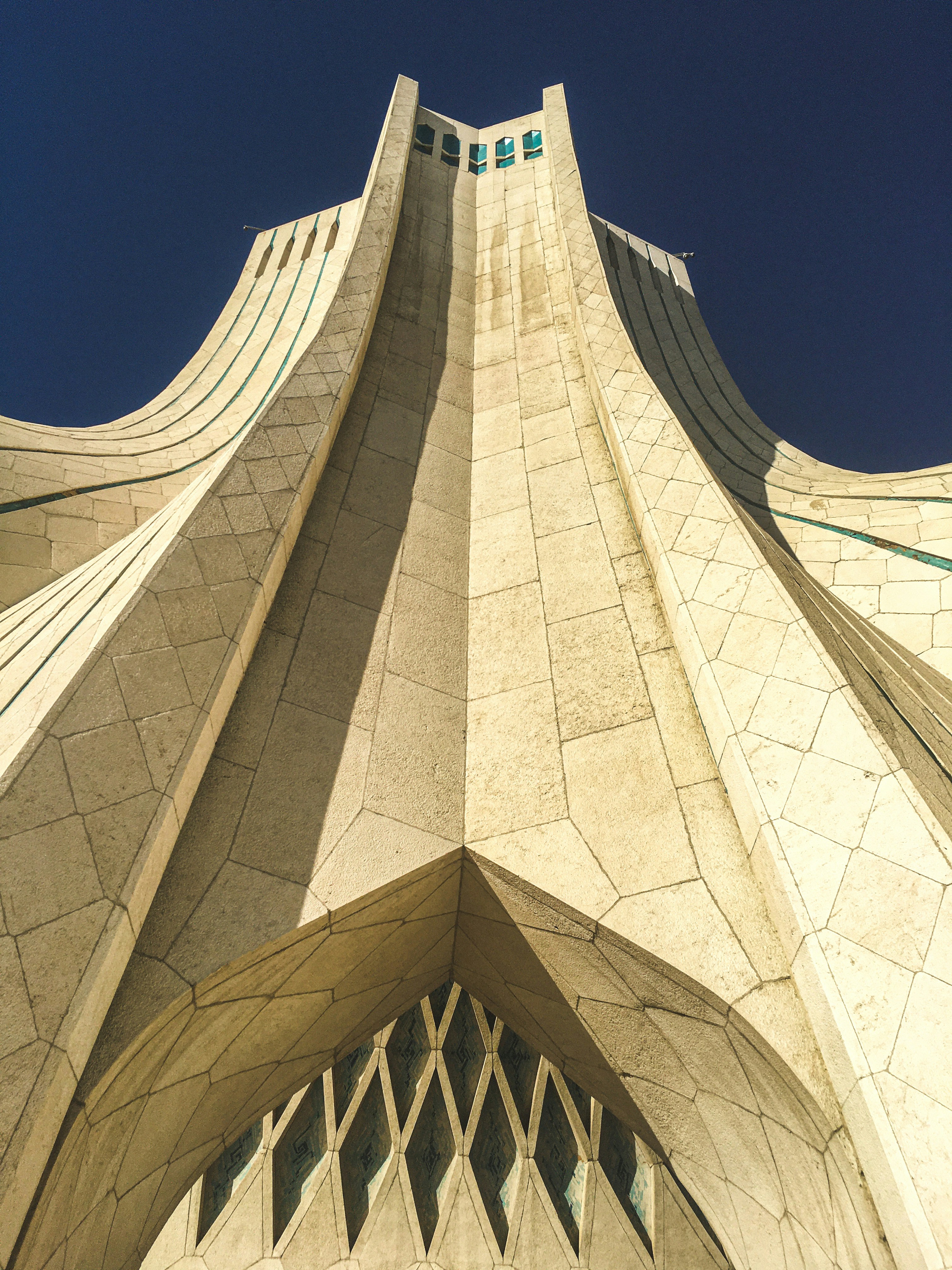 The intricate architectural details of a towering monument, showcasing its elegant curves and geometric patterns against a clear blue sky.