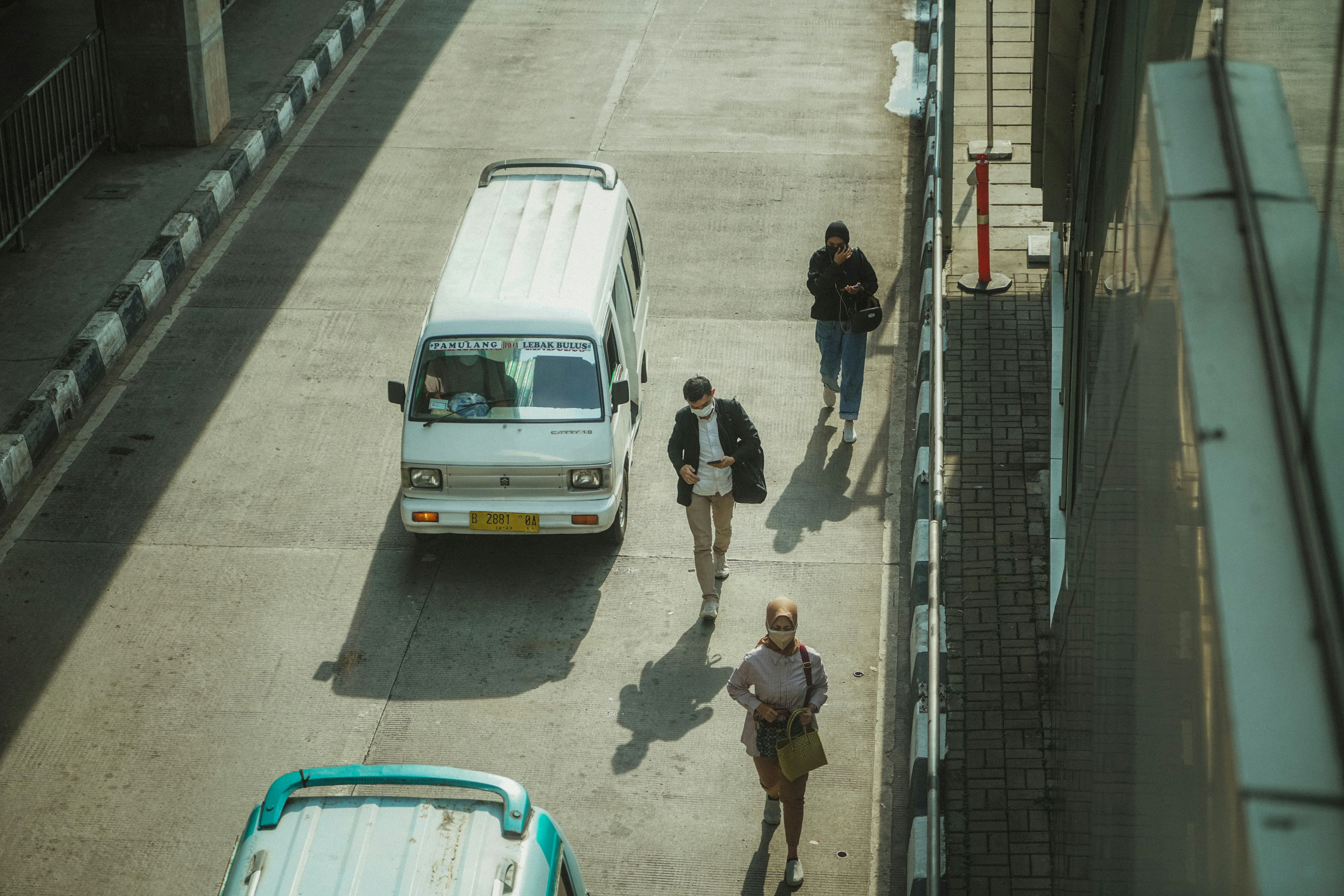 A group of people walking down a sidewalk next to a bus photo – Free ...
