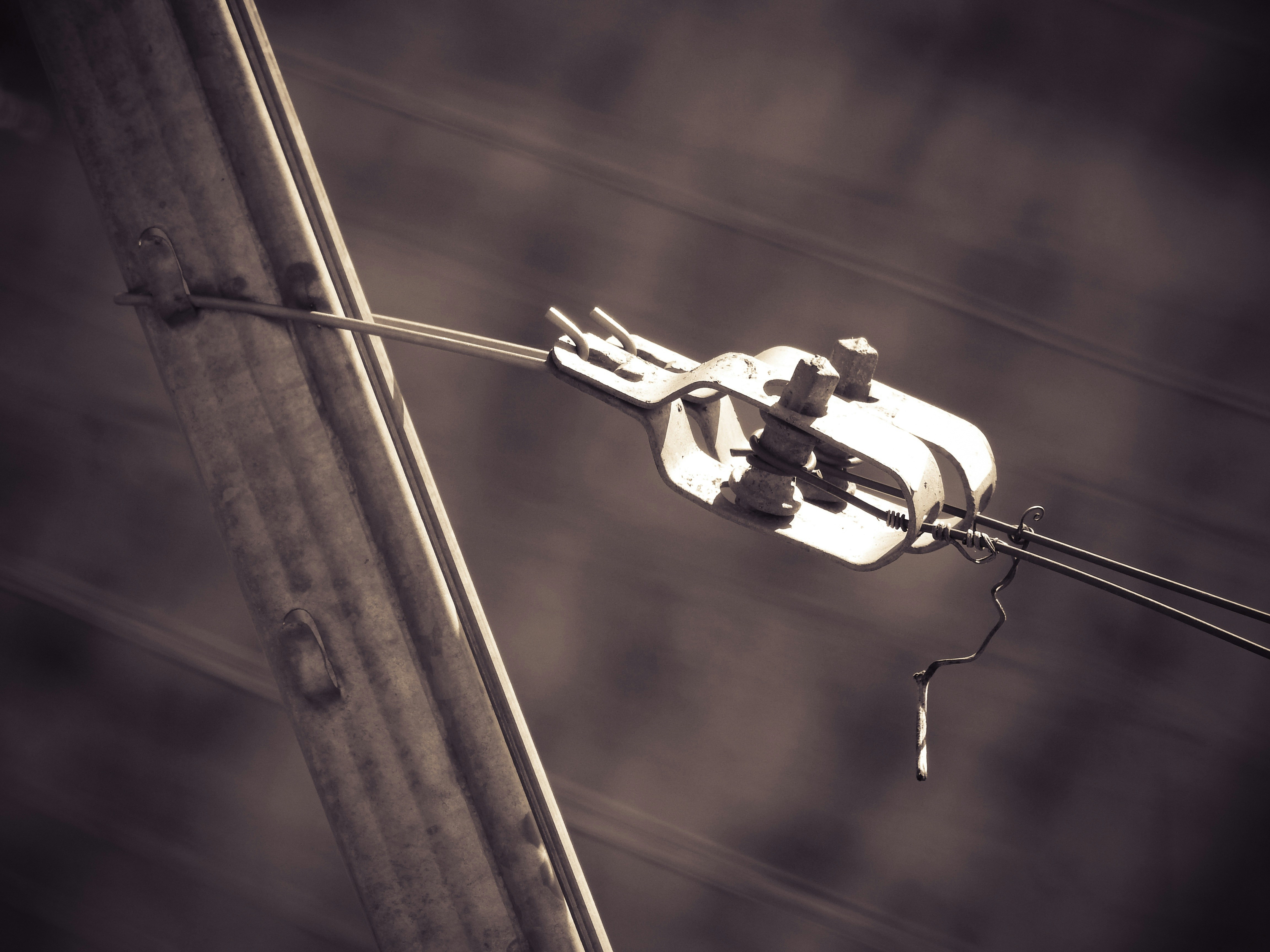 Midair Clamp: A Sepia Close-Up on a Taut Wire