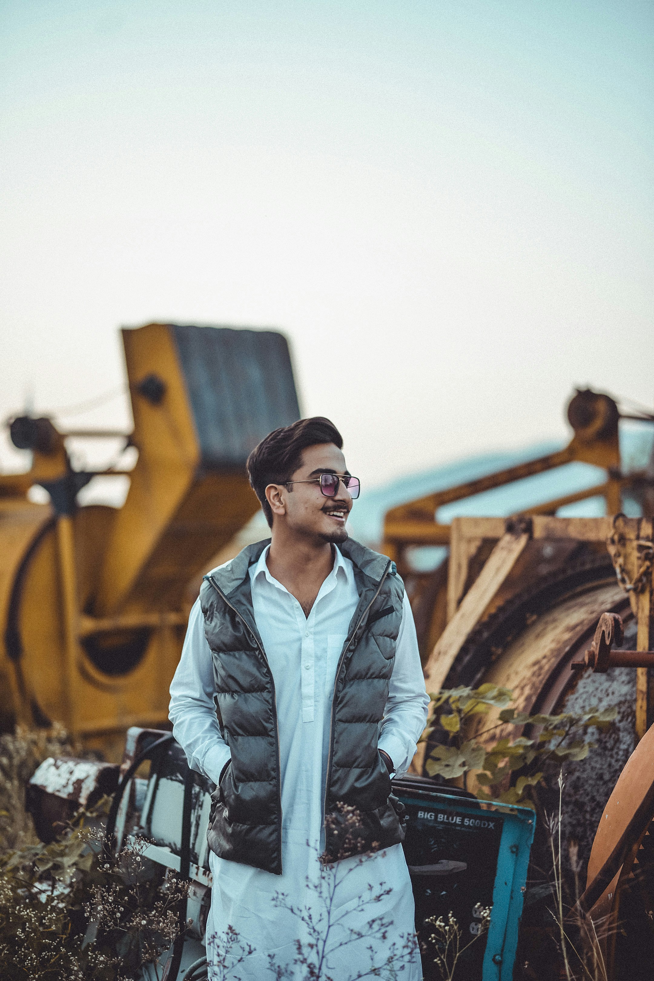 A man standing in front of a pile of junk photo – Free Apparel Image on ...