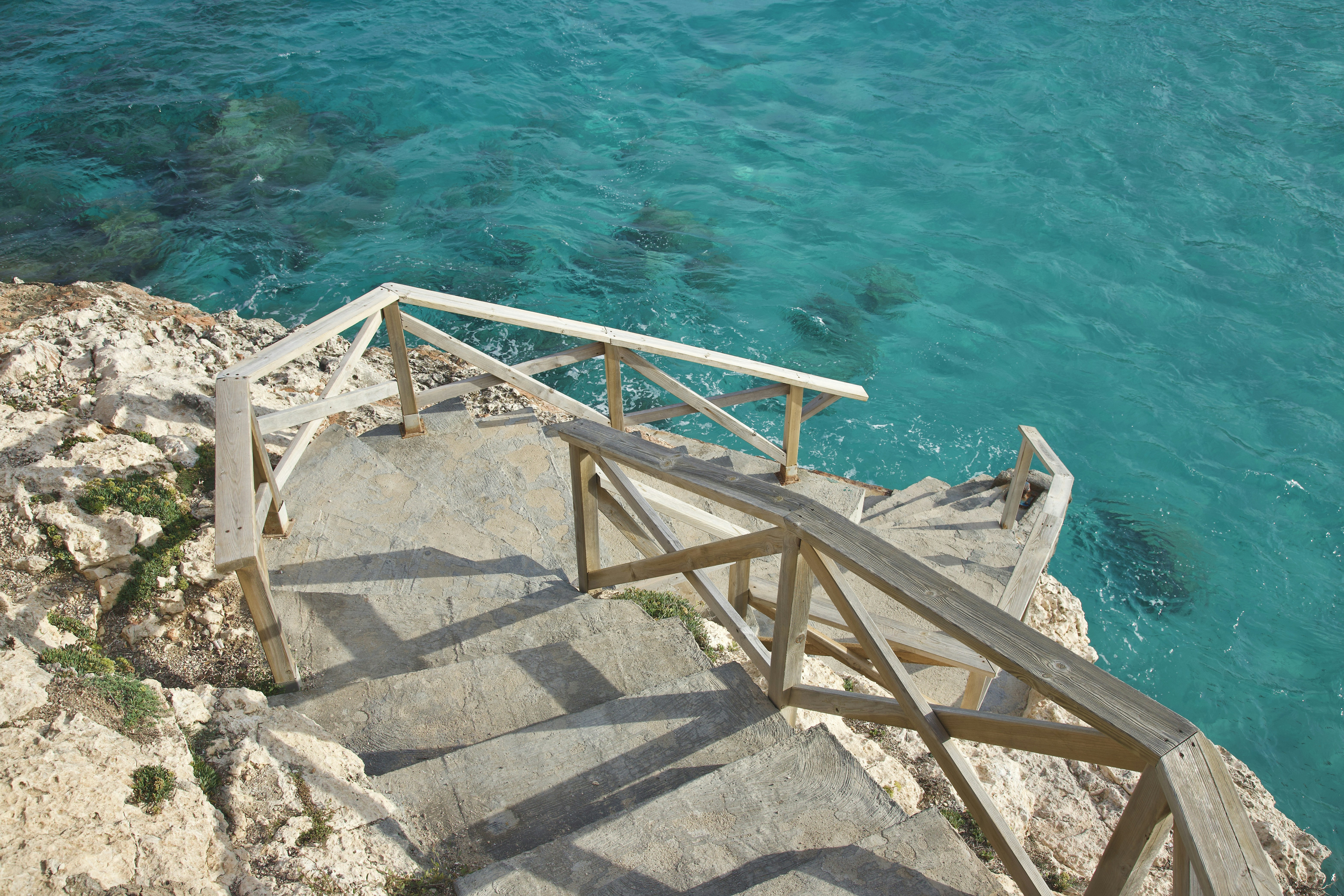 Stairway to the Turquoise Edge: Weathered Railings Descend to a Crystal Sea