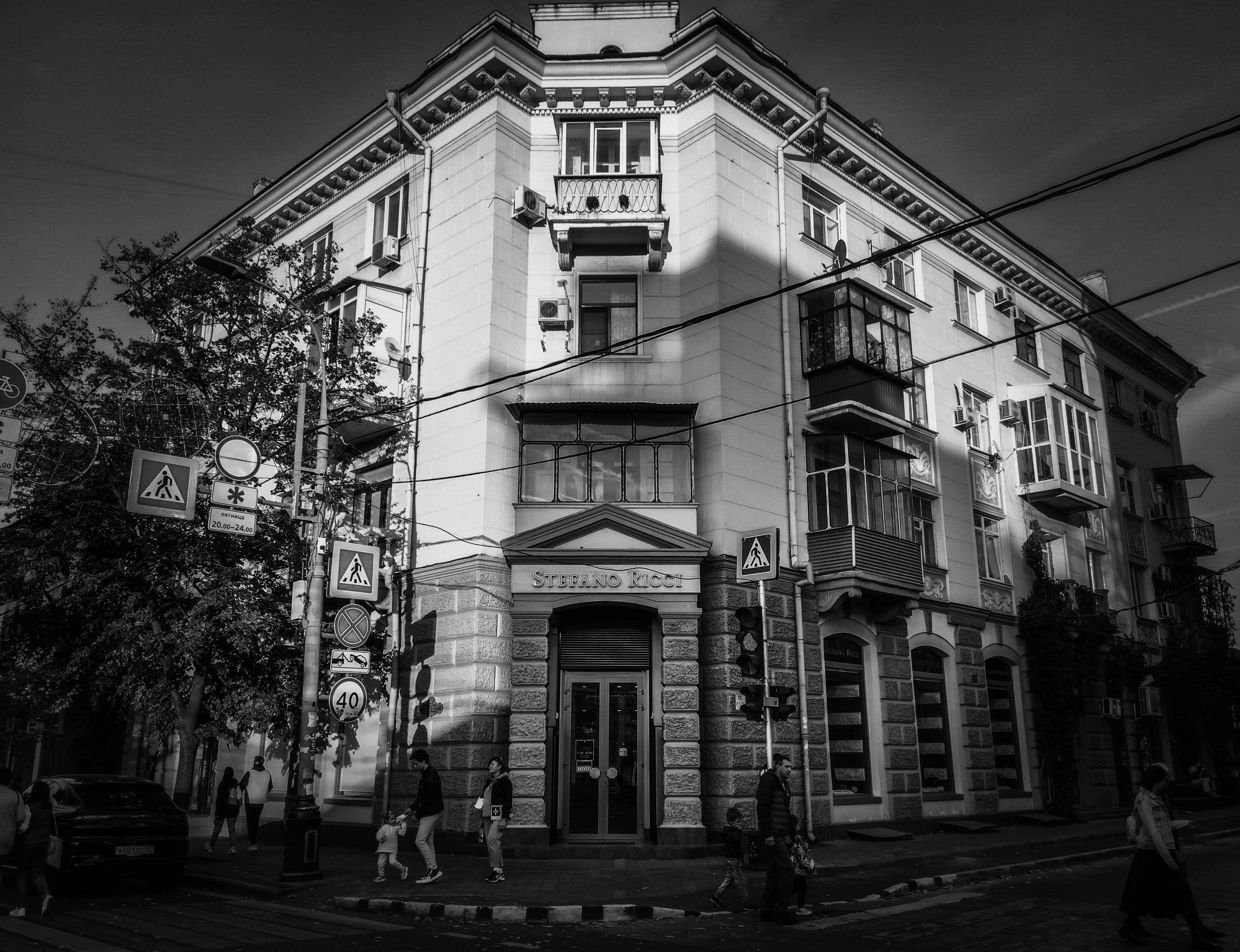 Historic building basking in dramatic light and shadow on a bustling street corner.