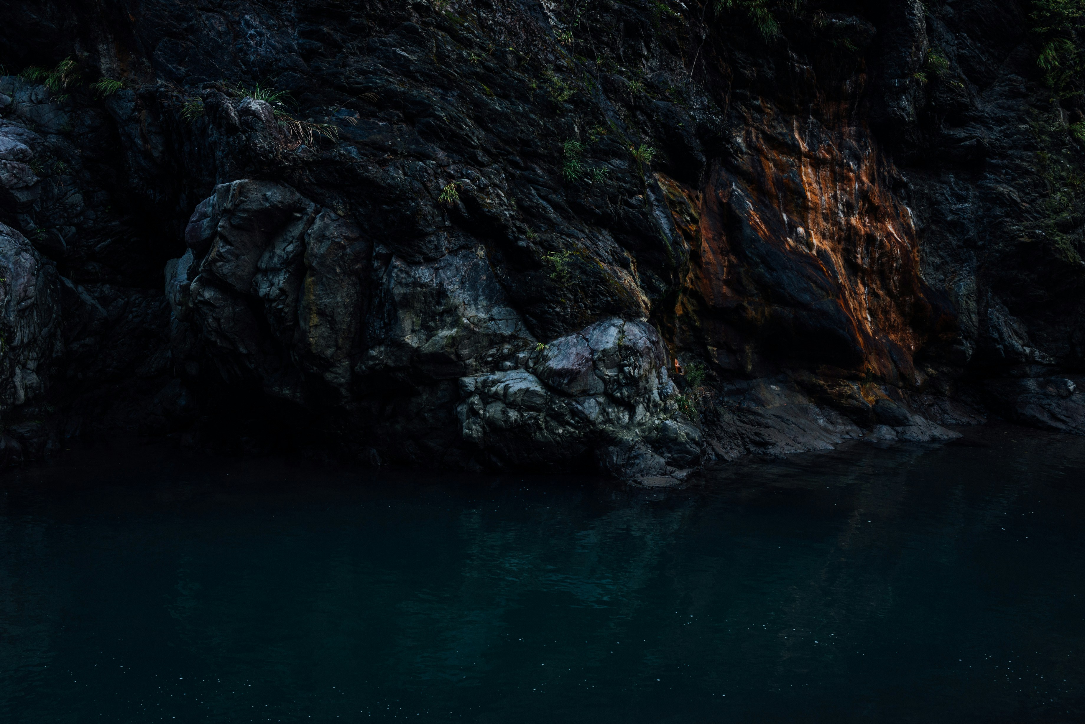 Un cuerpo de agua rodeado por un acantilado rocoso foto – Imagen de ...