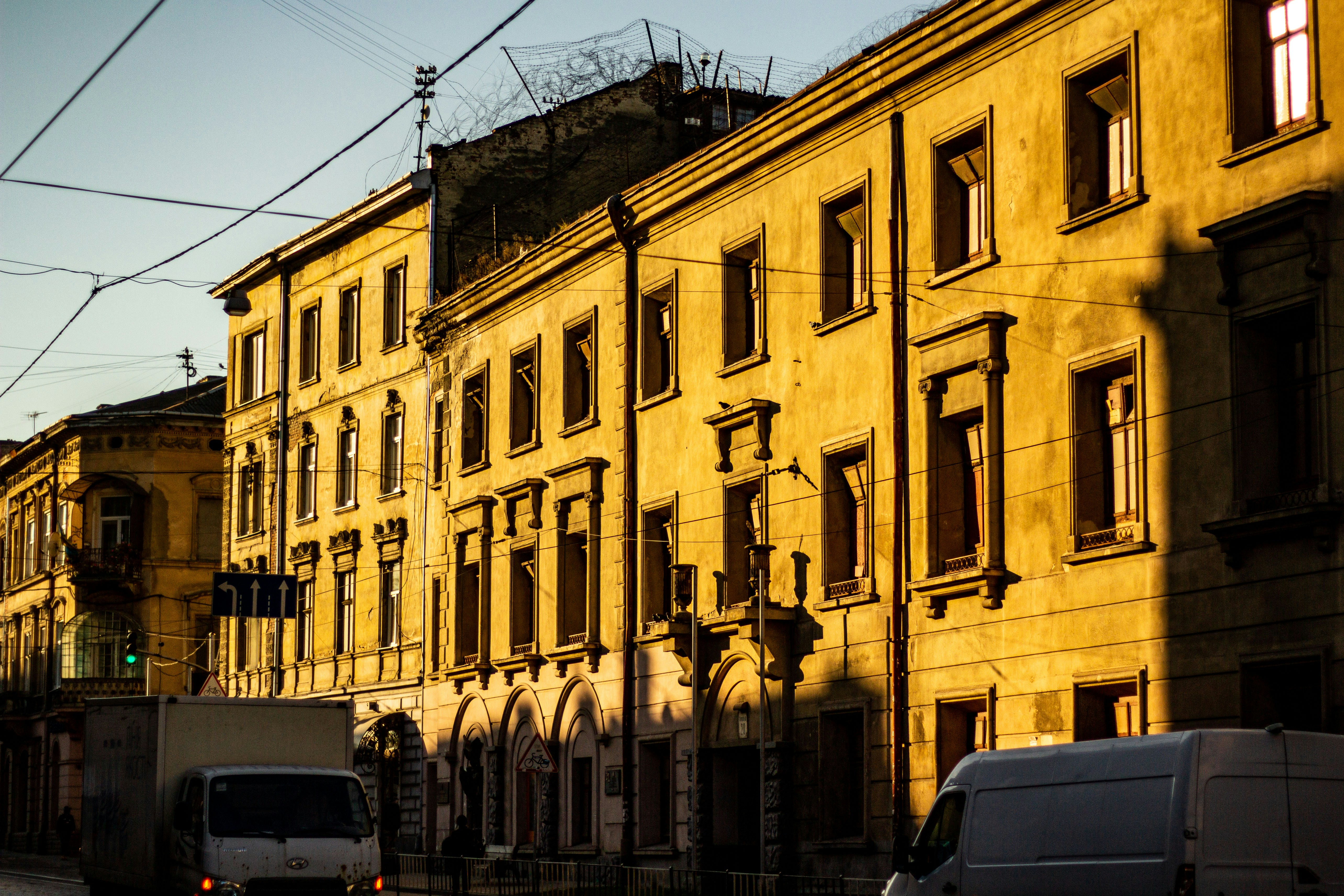 A city street lined with tall yellow buildings photo – Free Urban Image ...
