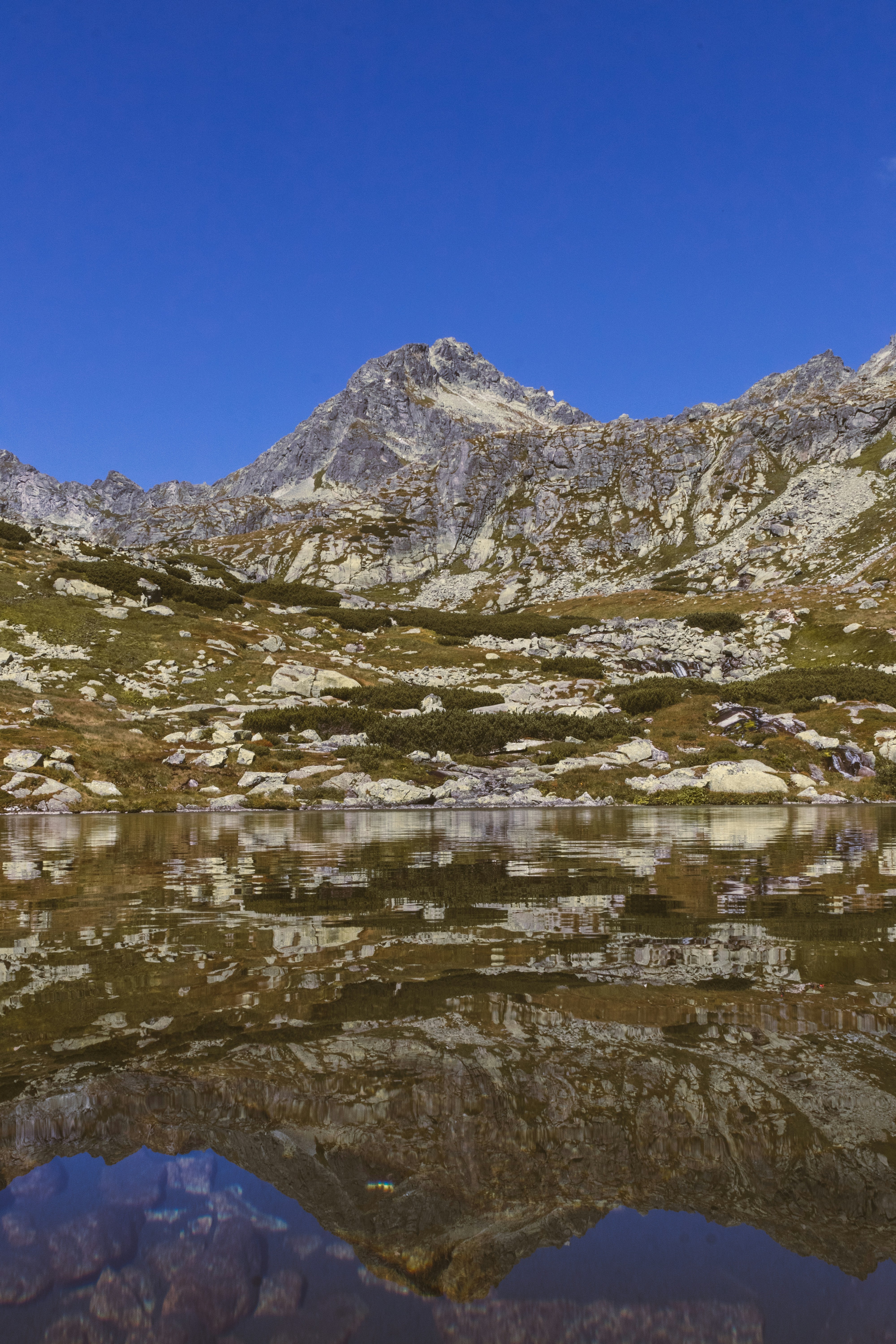 A mountain range reflected in the still water of a lake photo – Free ...