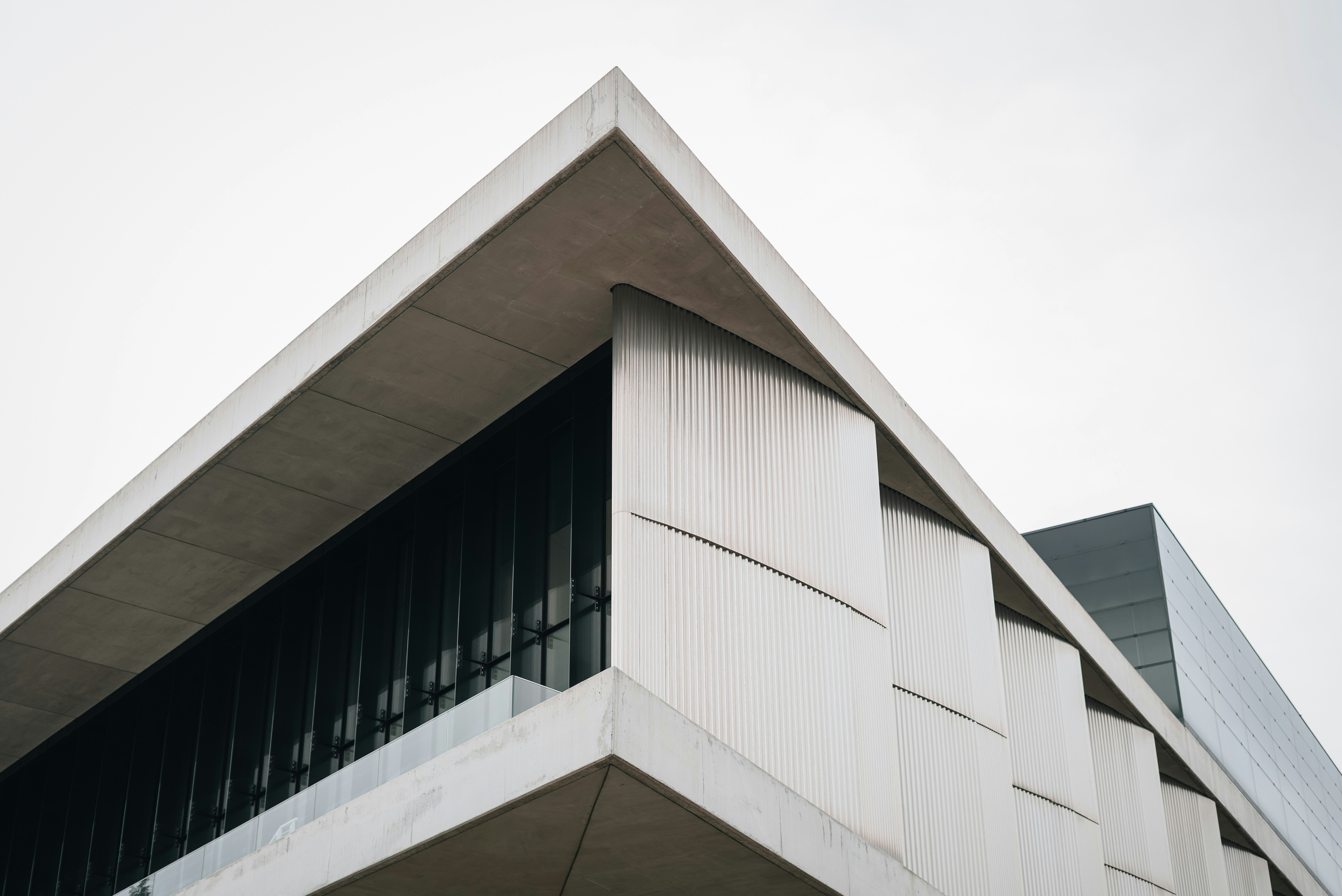Abstract view of a contemporary building showcasing geometric lines and textures with a focus on its angular roof design.