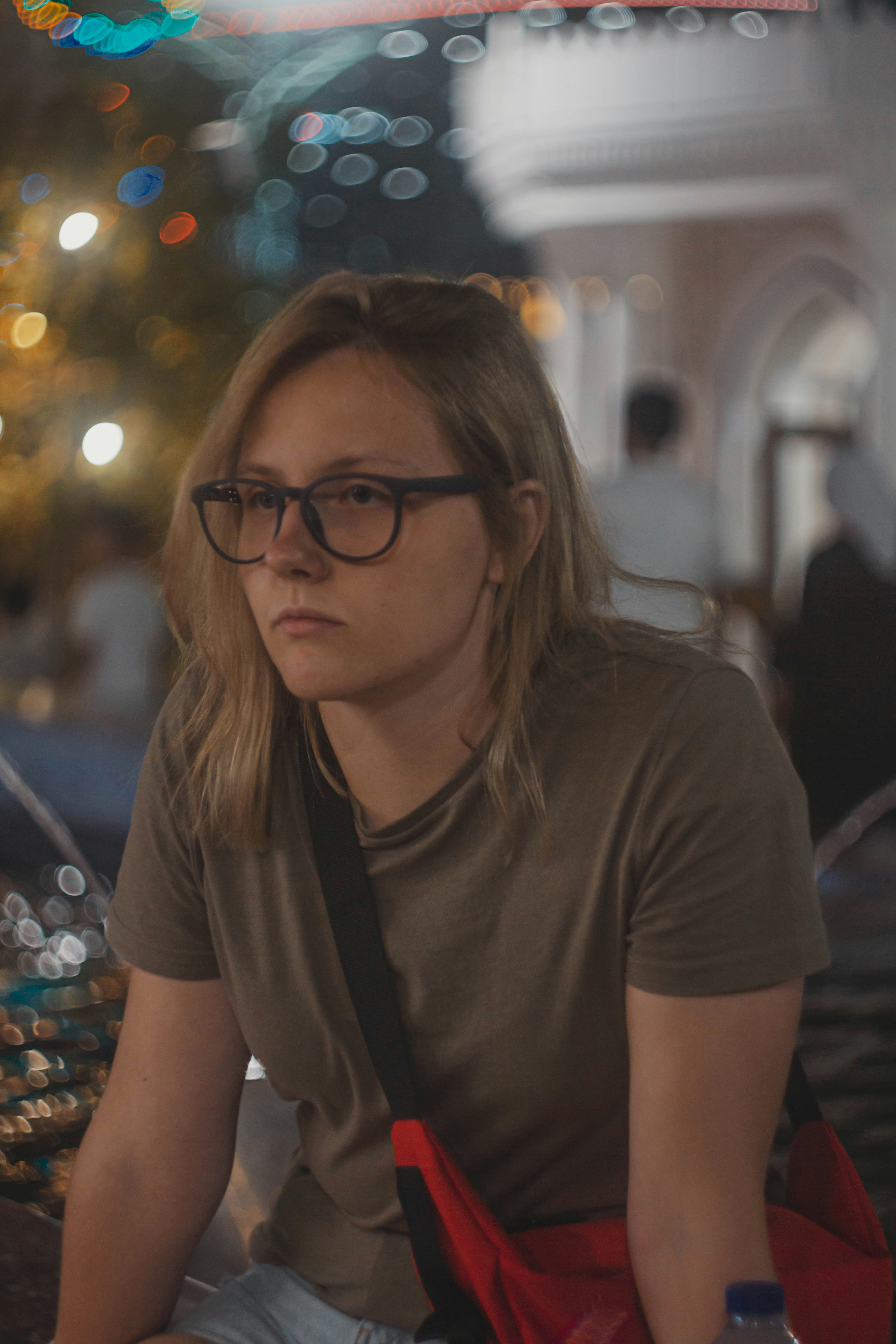 a woman wearing glasses sitting on a bench