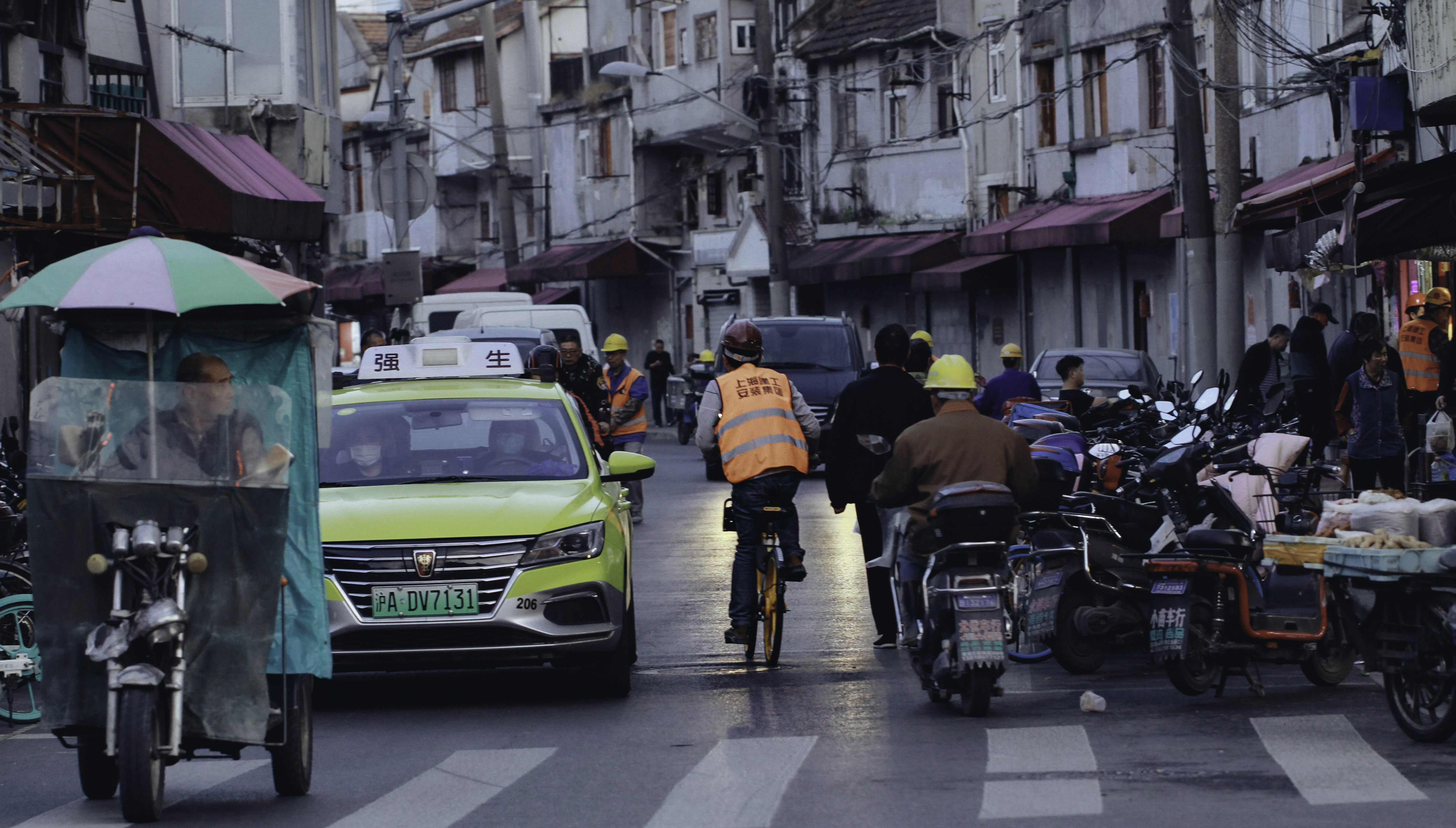 Crossing Current: A Lime Taxi and Cyclist Thread Through a Busy Market Street