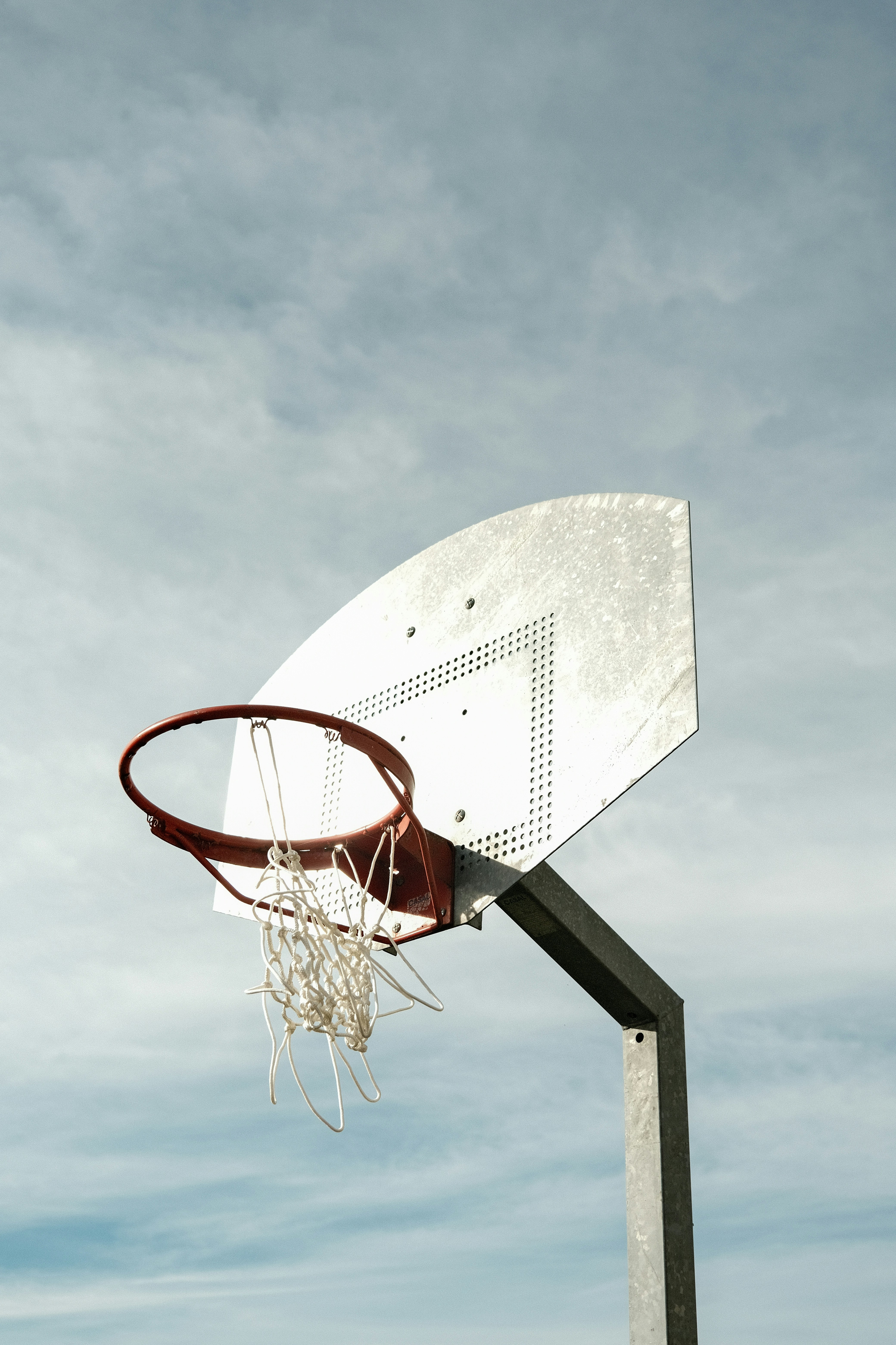 A basketball going through the rim of a basketball hoop photo – Free La ...