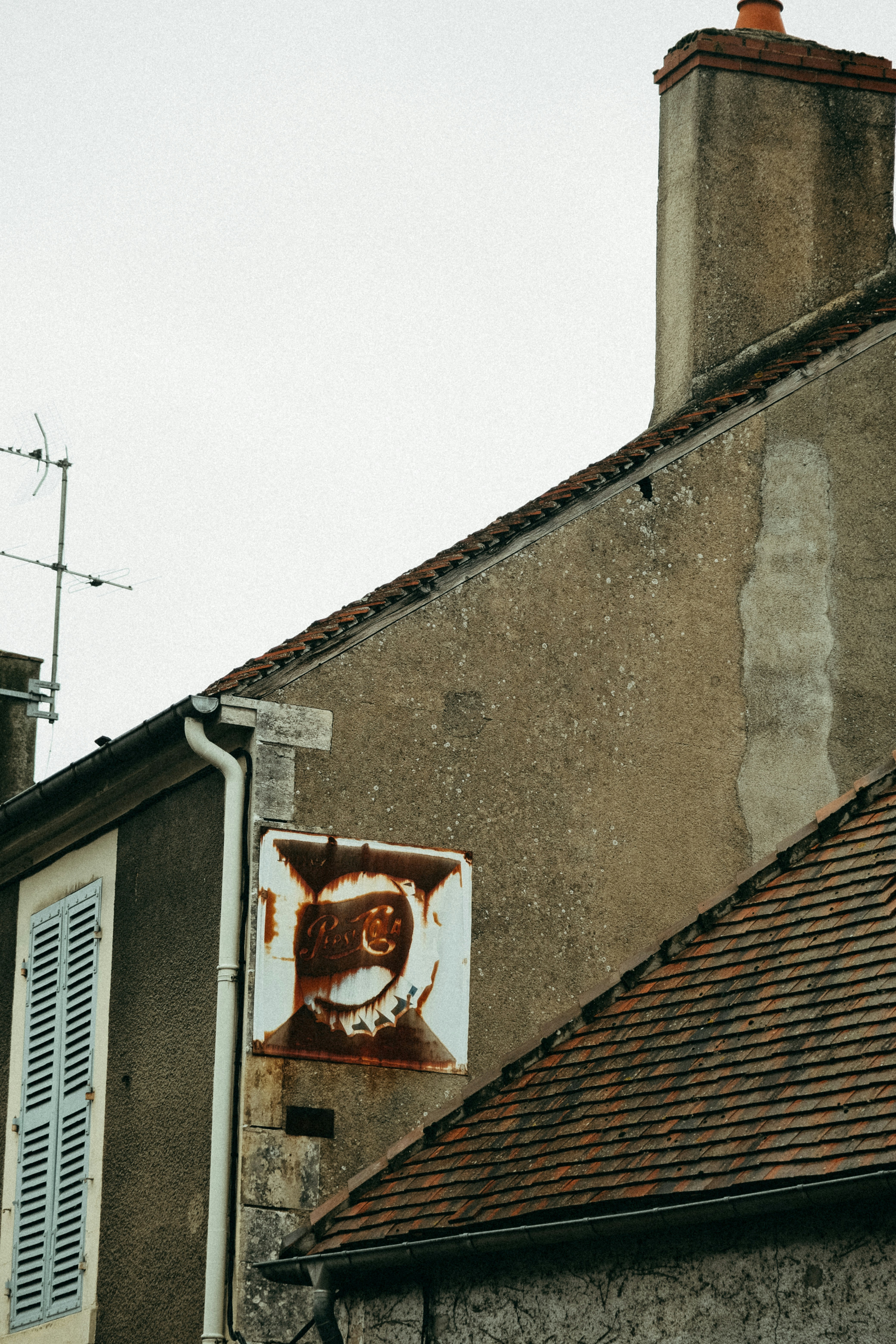 Rust-Crusted Cat Emblem Adorning a Quiet Rooftop