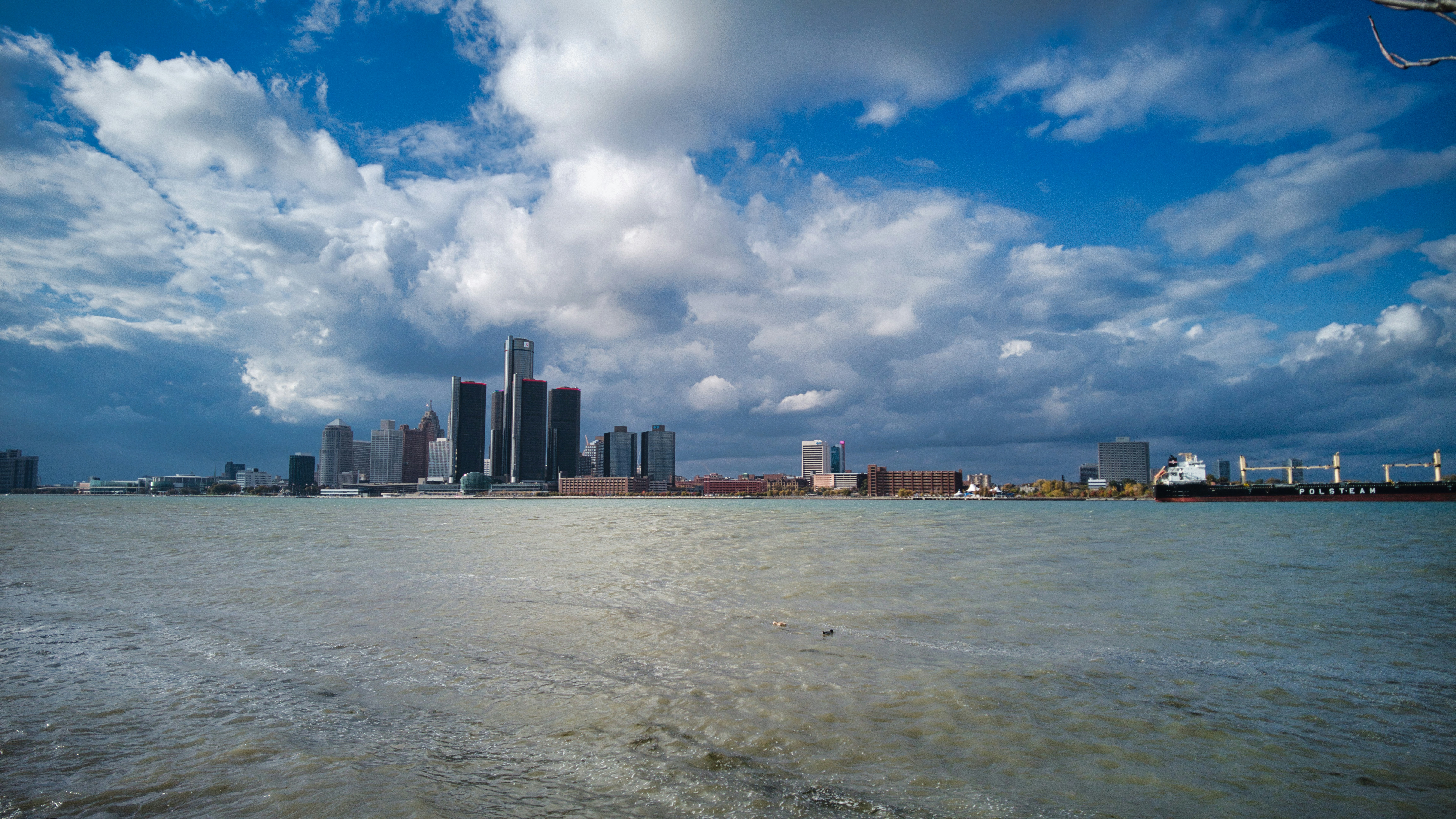 a large body of water with a city in the background
