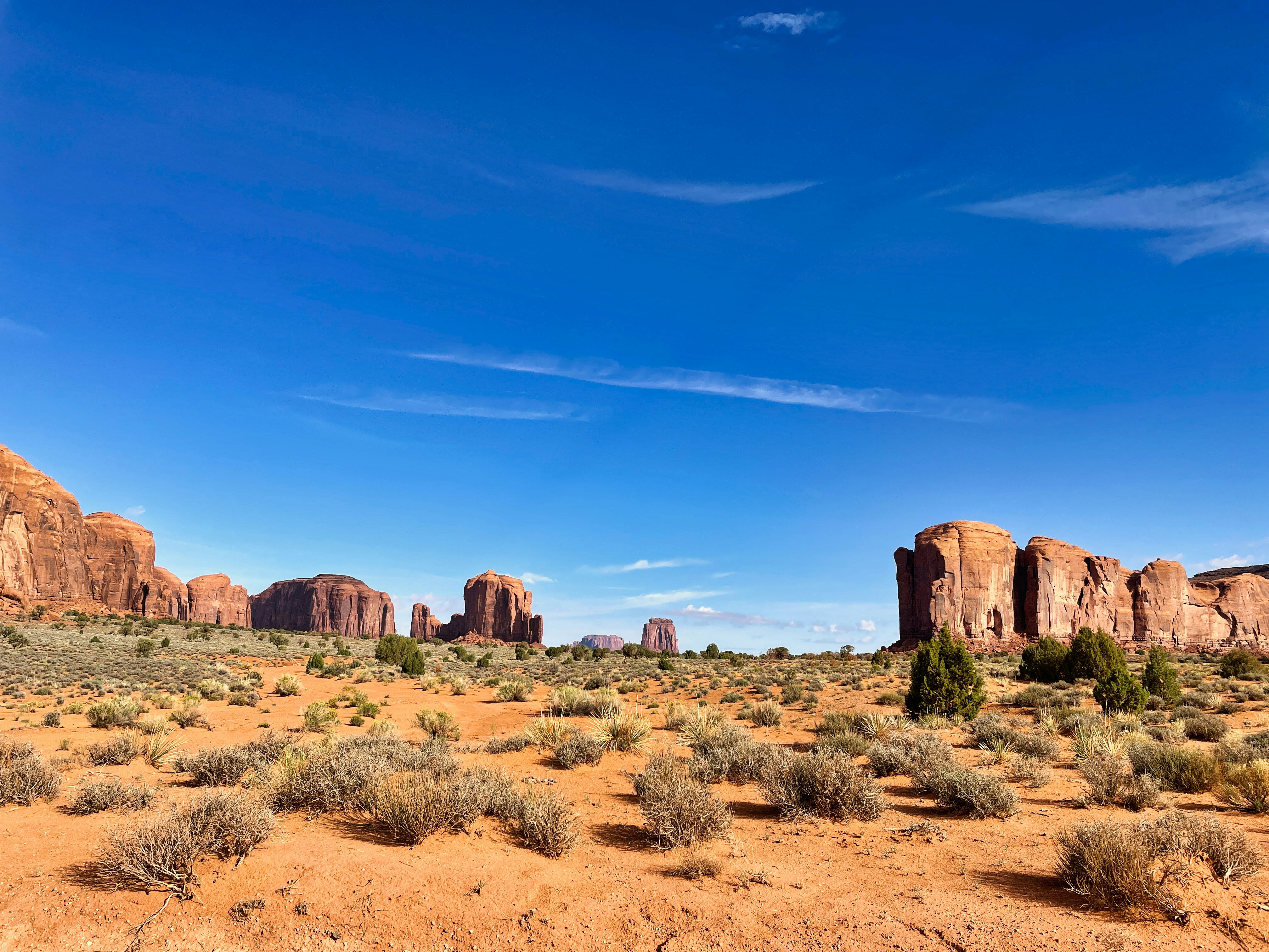 A desert landscape with rocks and bushes under a blue sky photo – Free ...