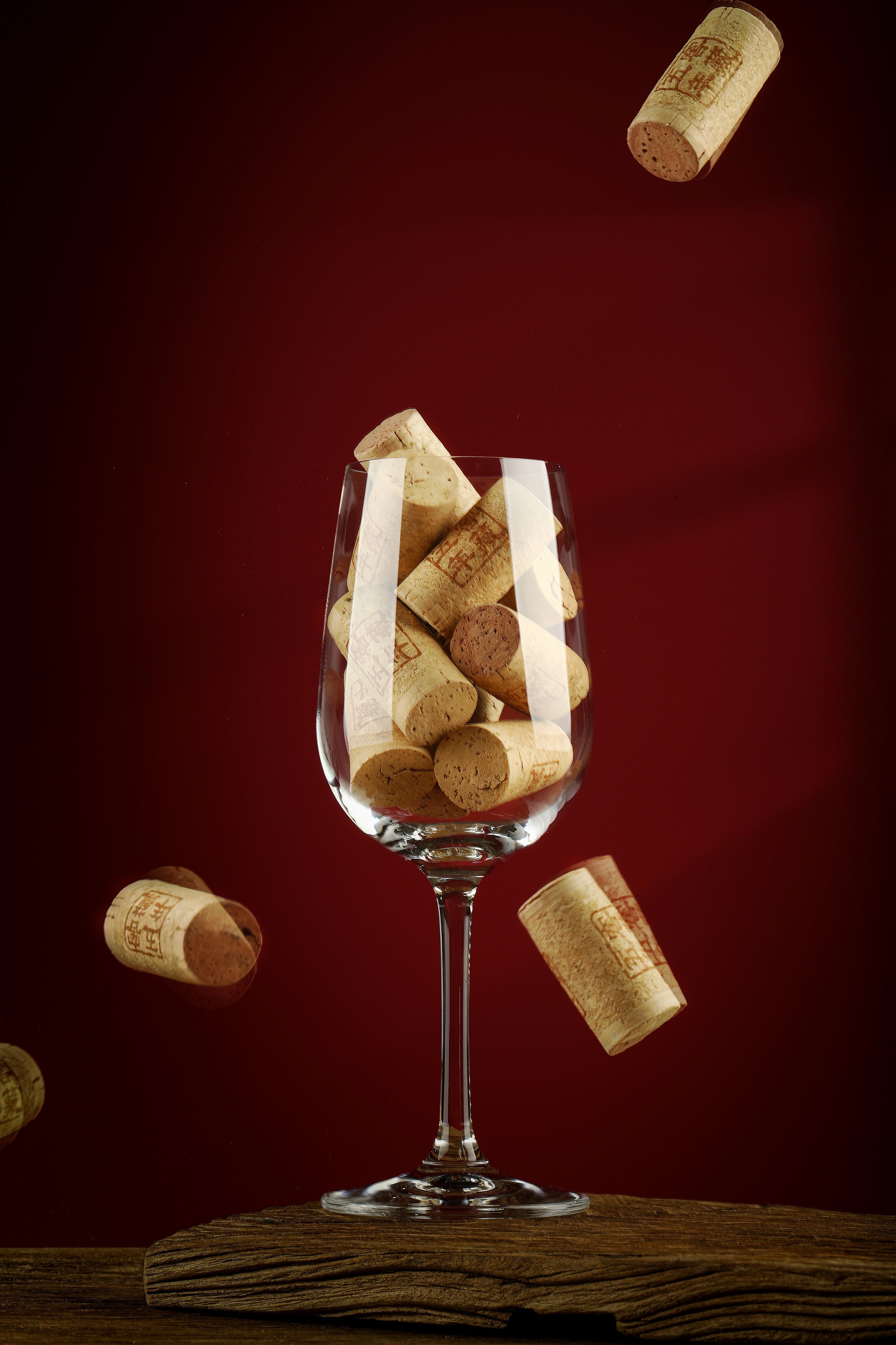 A wine glass filled with wine corks on top of a table photo – Free ...