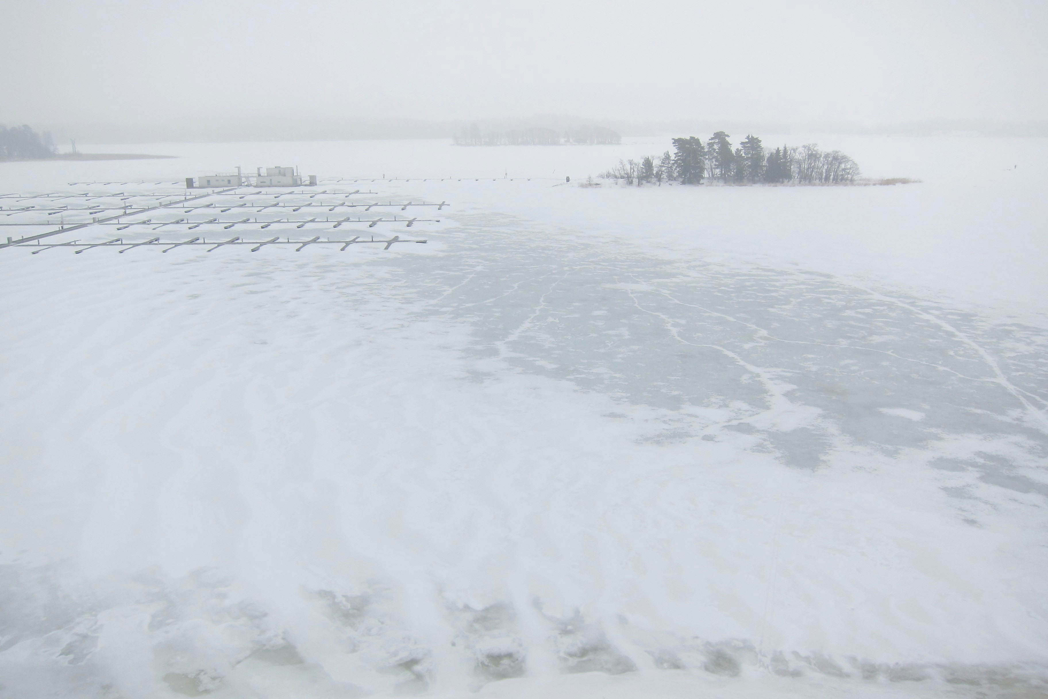 Frozen Horizon: A Snow-bleached River Sees Islands and Docks Fade into Quiet Frost