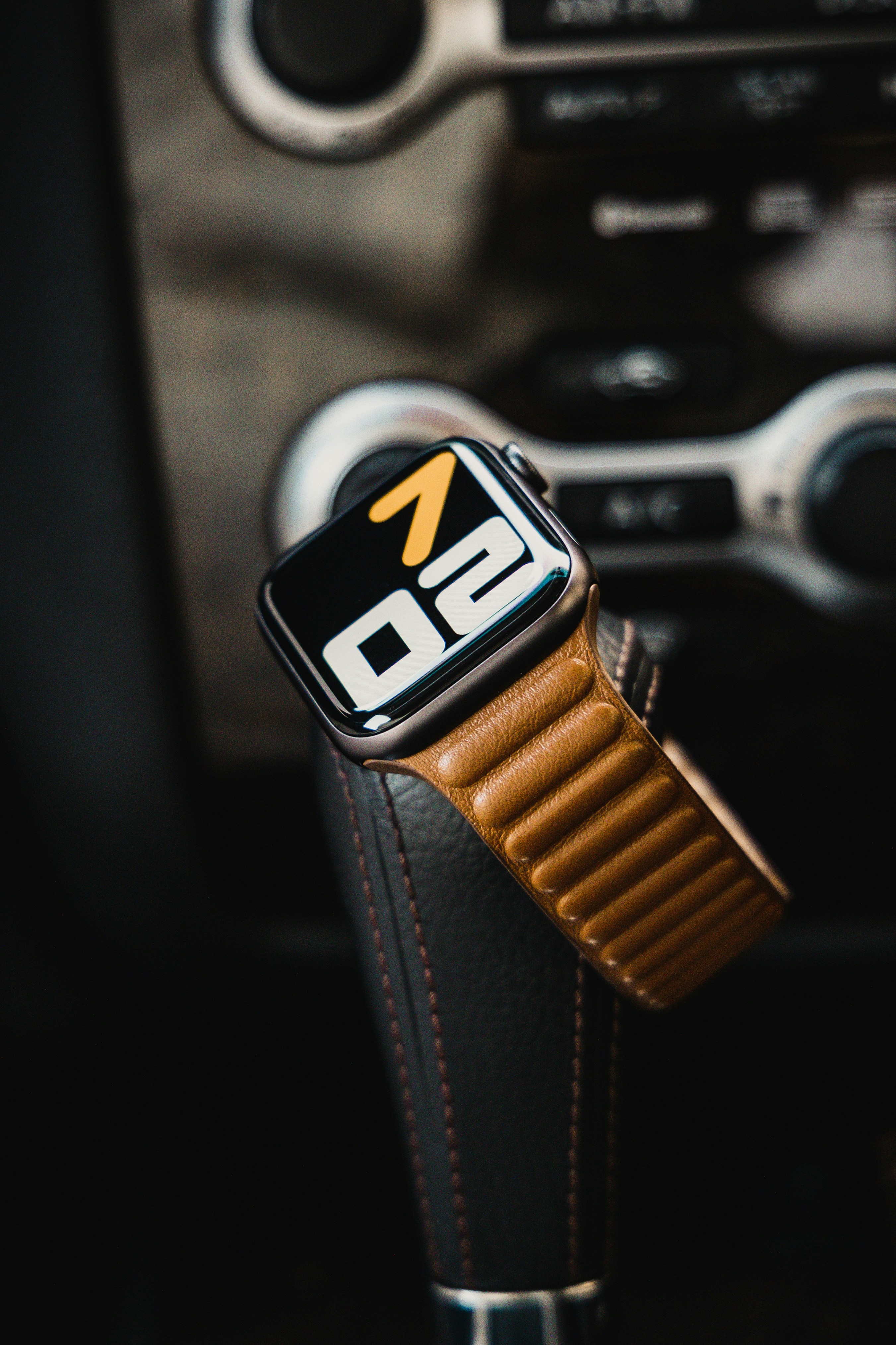 a close up of an apple watch on a car steering wheel