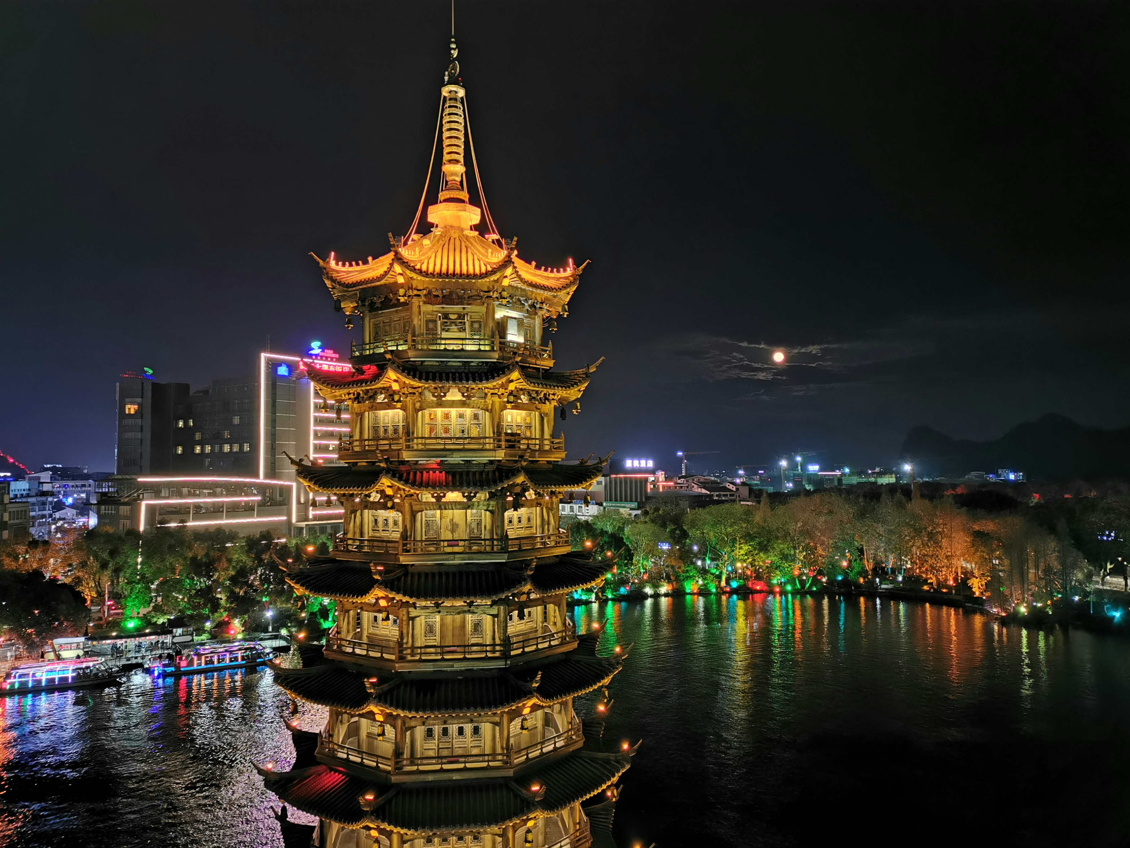 Golden Pagoda by the Riverside: Night Lights Reflect the City
