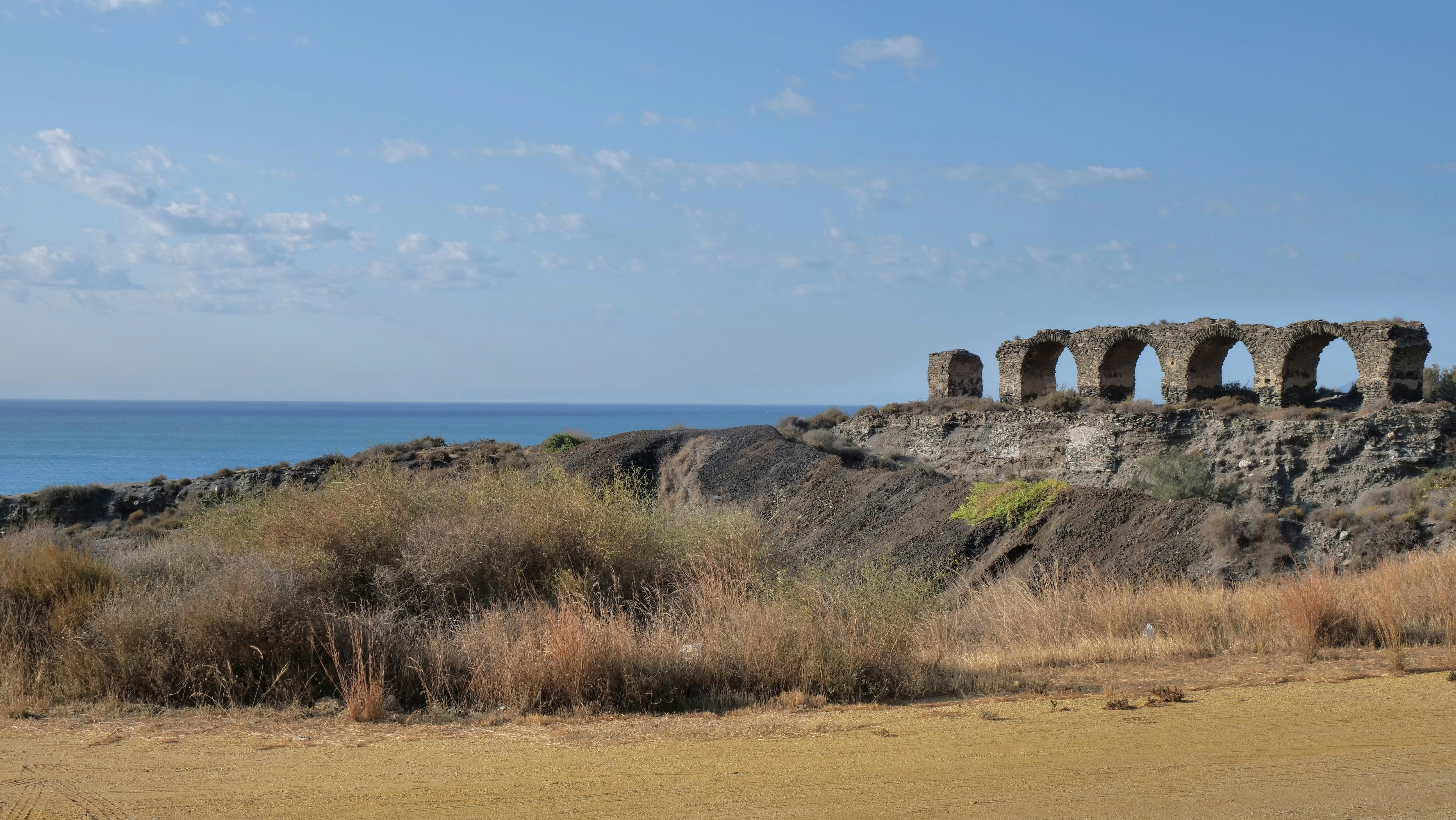 A large stone structure sitting on top of a dirt hill photo – Free ...