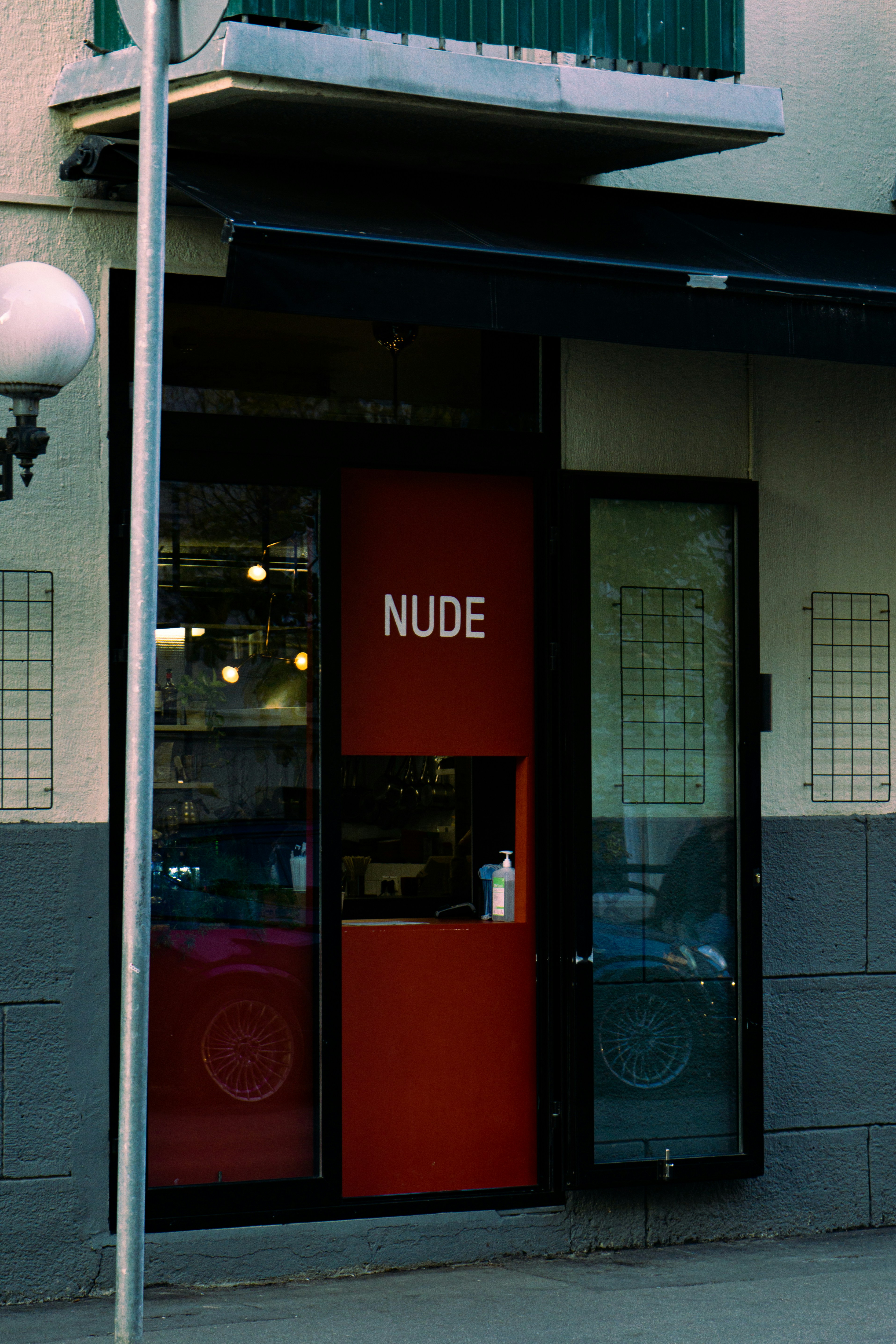 Red Door with NUDE Sign: A Minimal Storefront in Glass and Steel