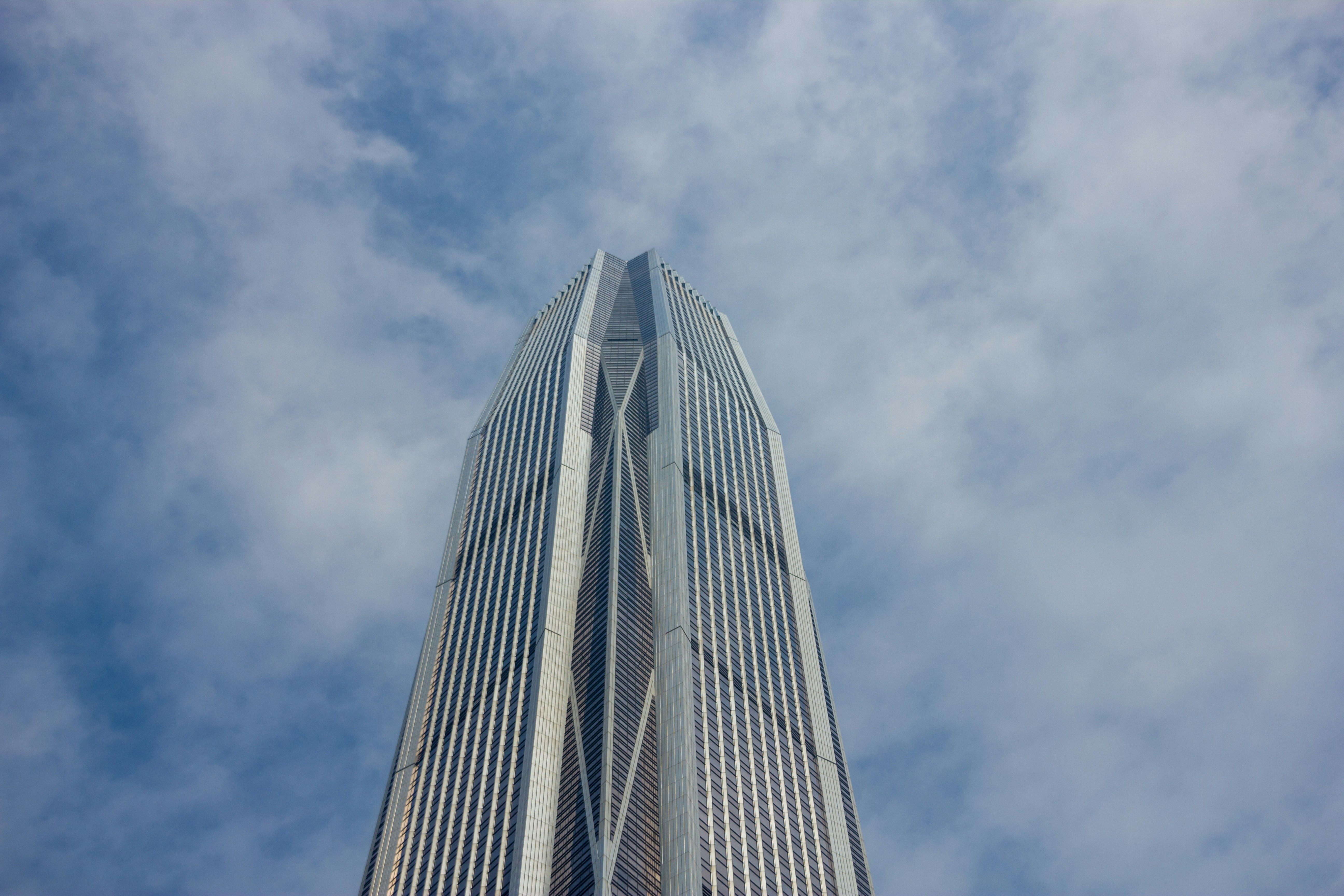 Sleek skyscraper stretching towards a cloudy sky, showcasing contemporary architecture and design.