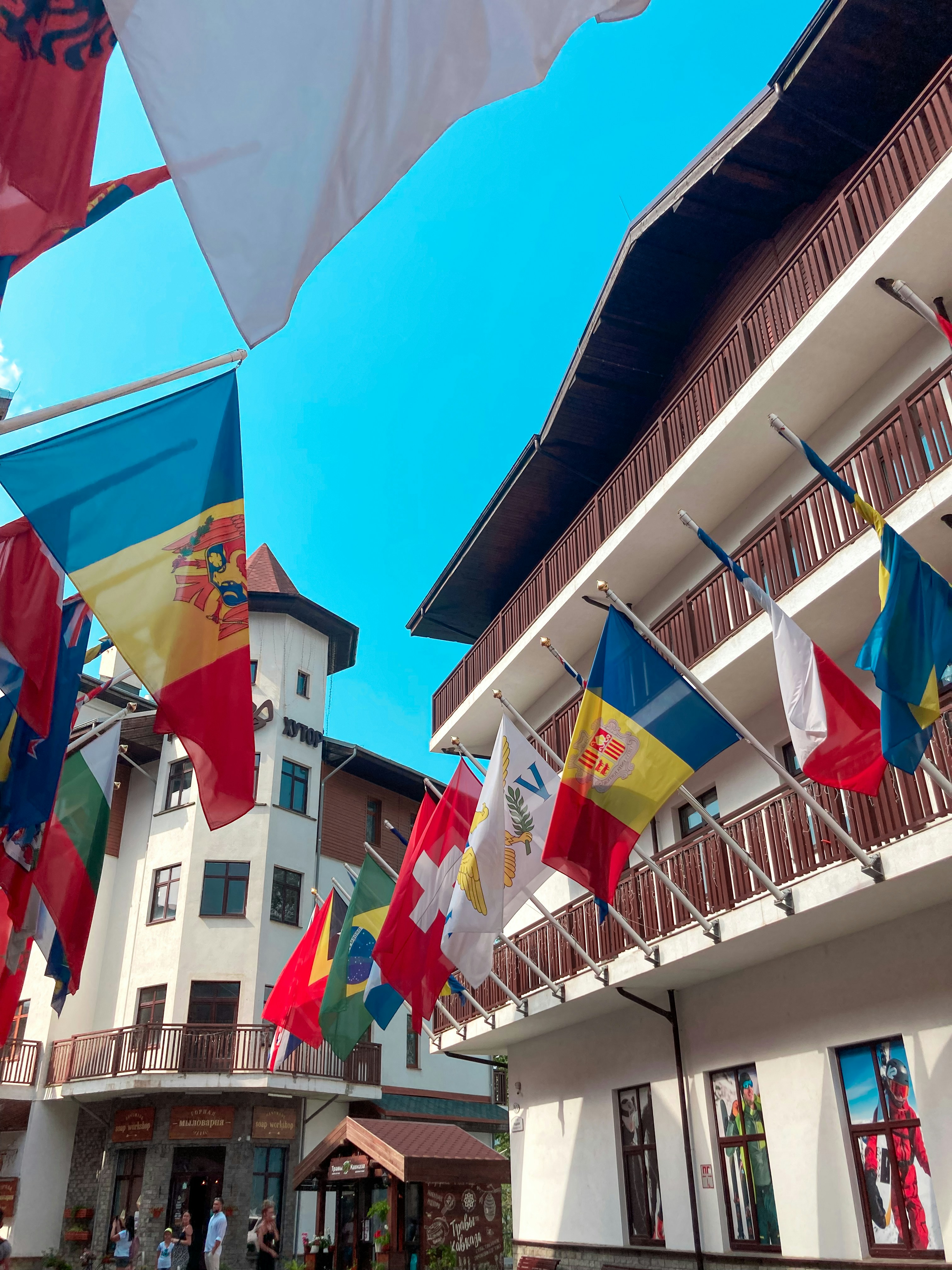 A group of flags hanging from the side of a building photo – Free ...