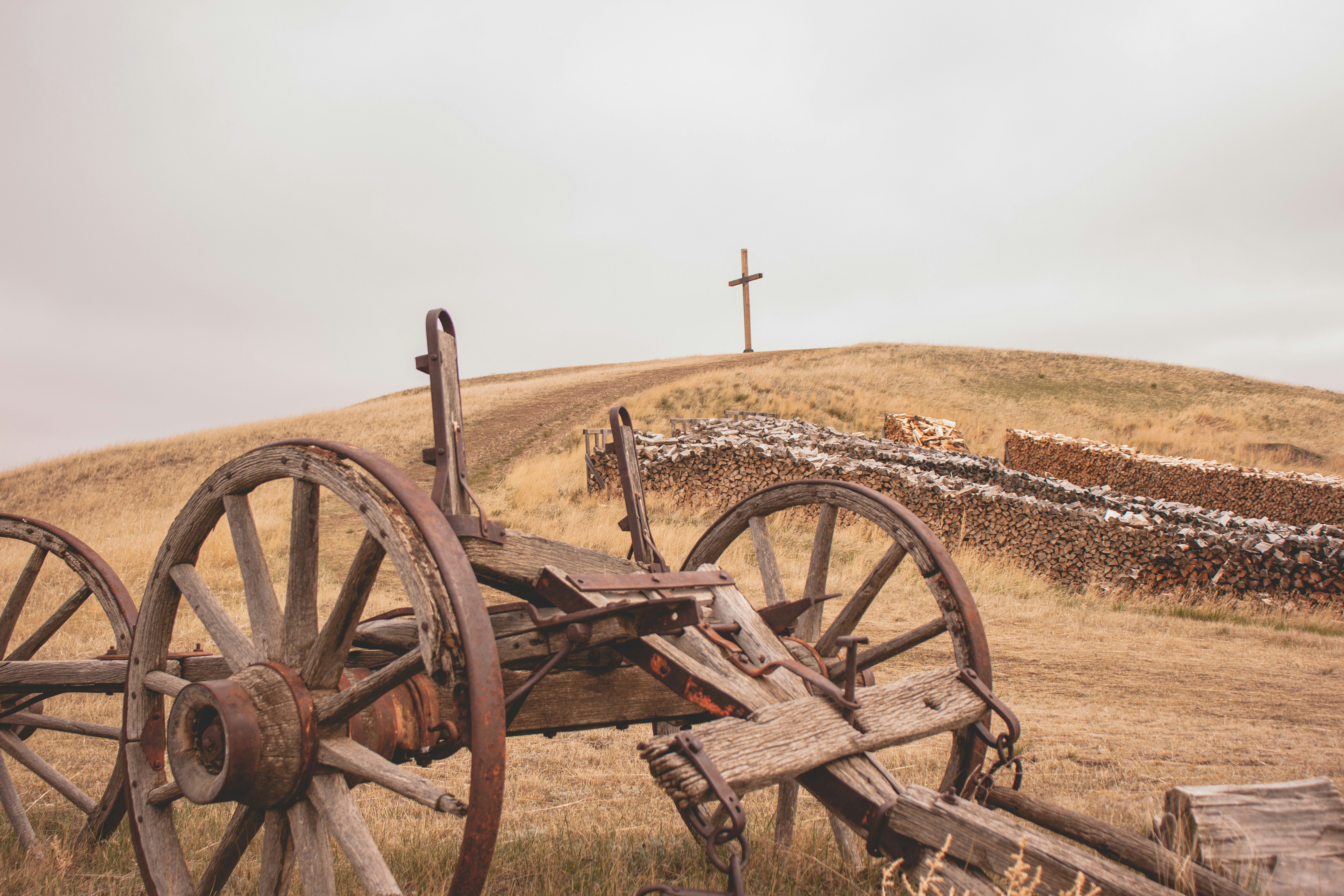 an old wooden wagon sitting on top of a dry grass field