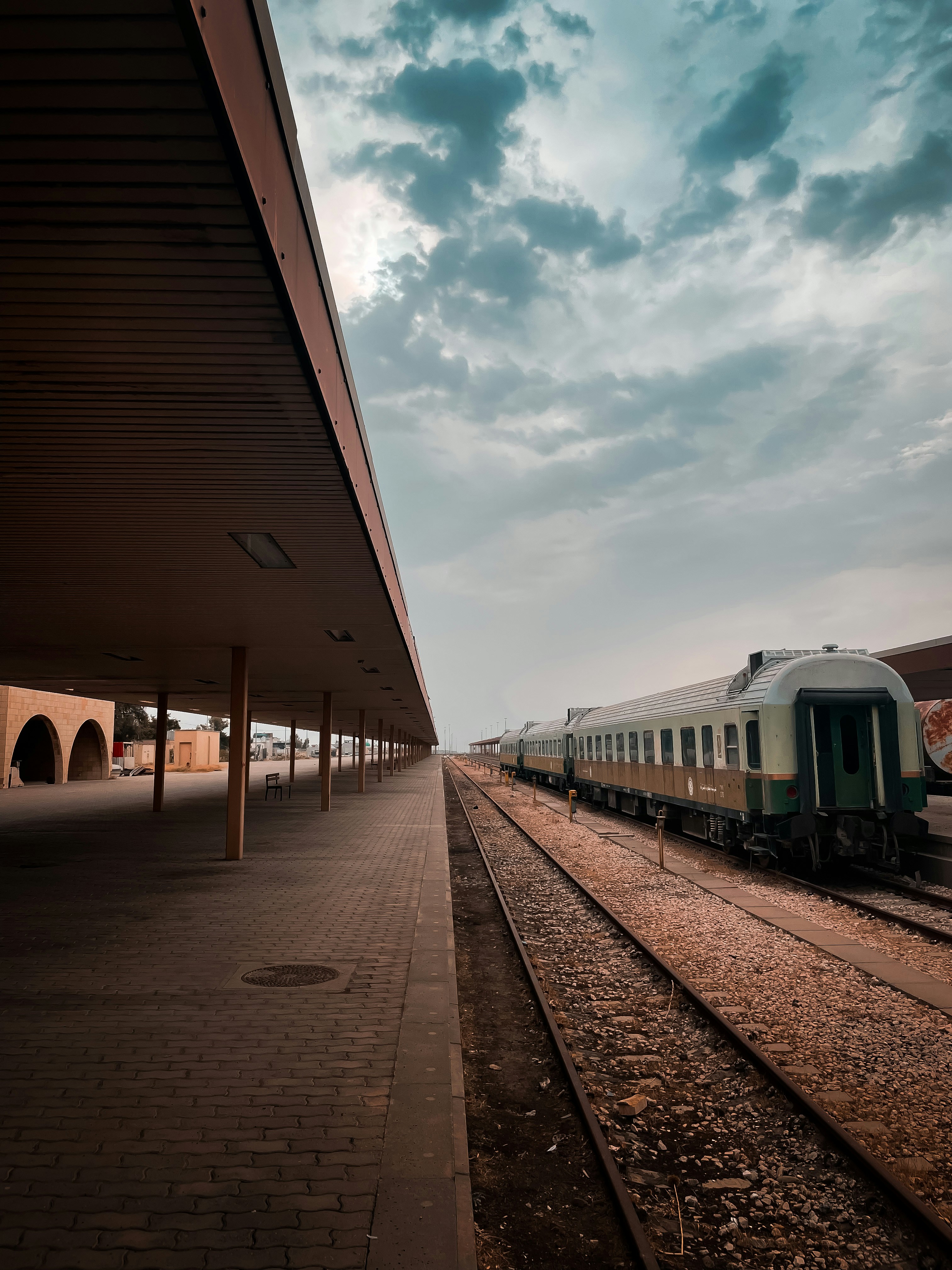 A train on a train track next to a building photo – Free Iraq Image on ...