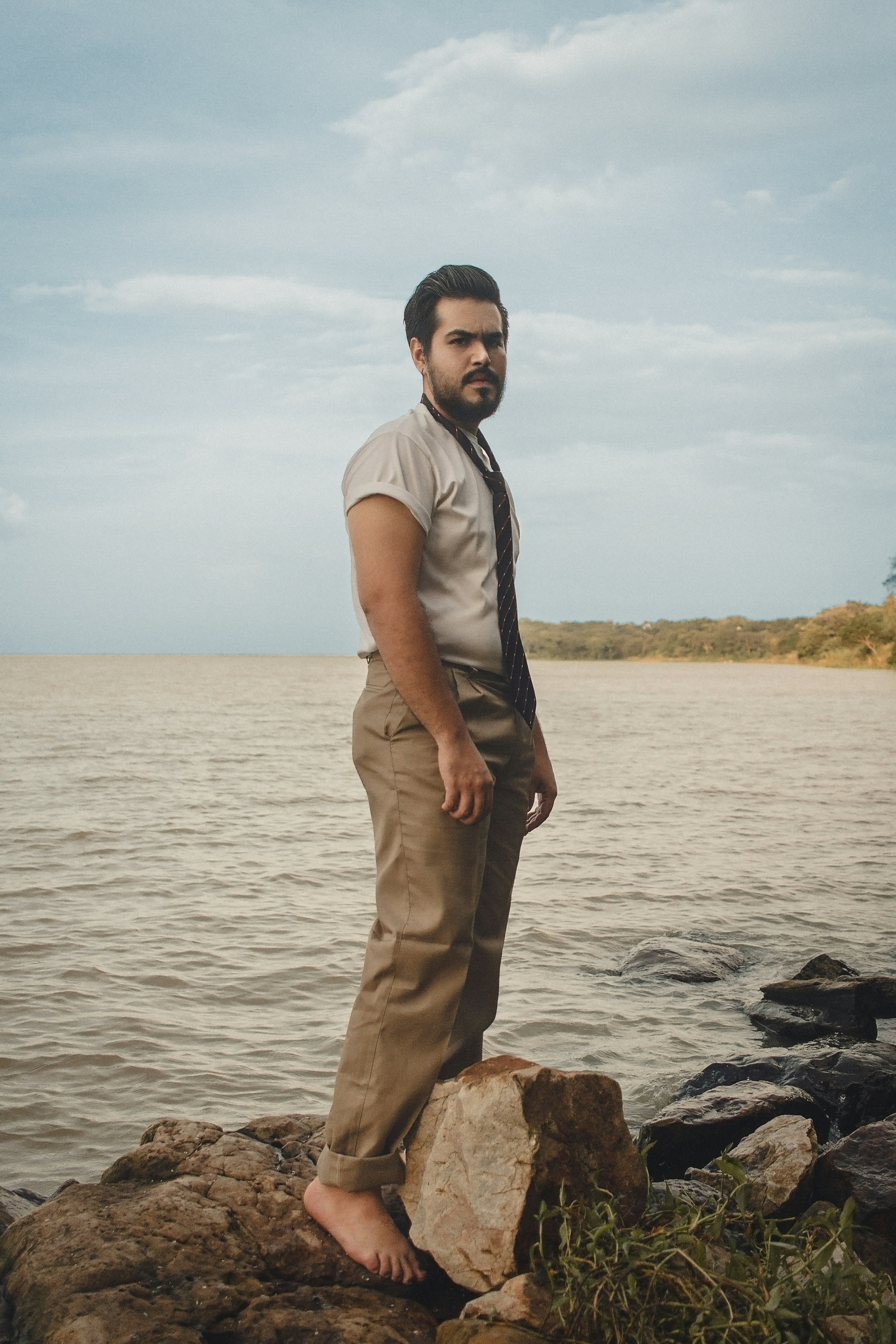 Barefoot by the Breakwater: A Poised Figure Against Sea and Sky