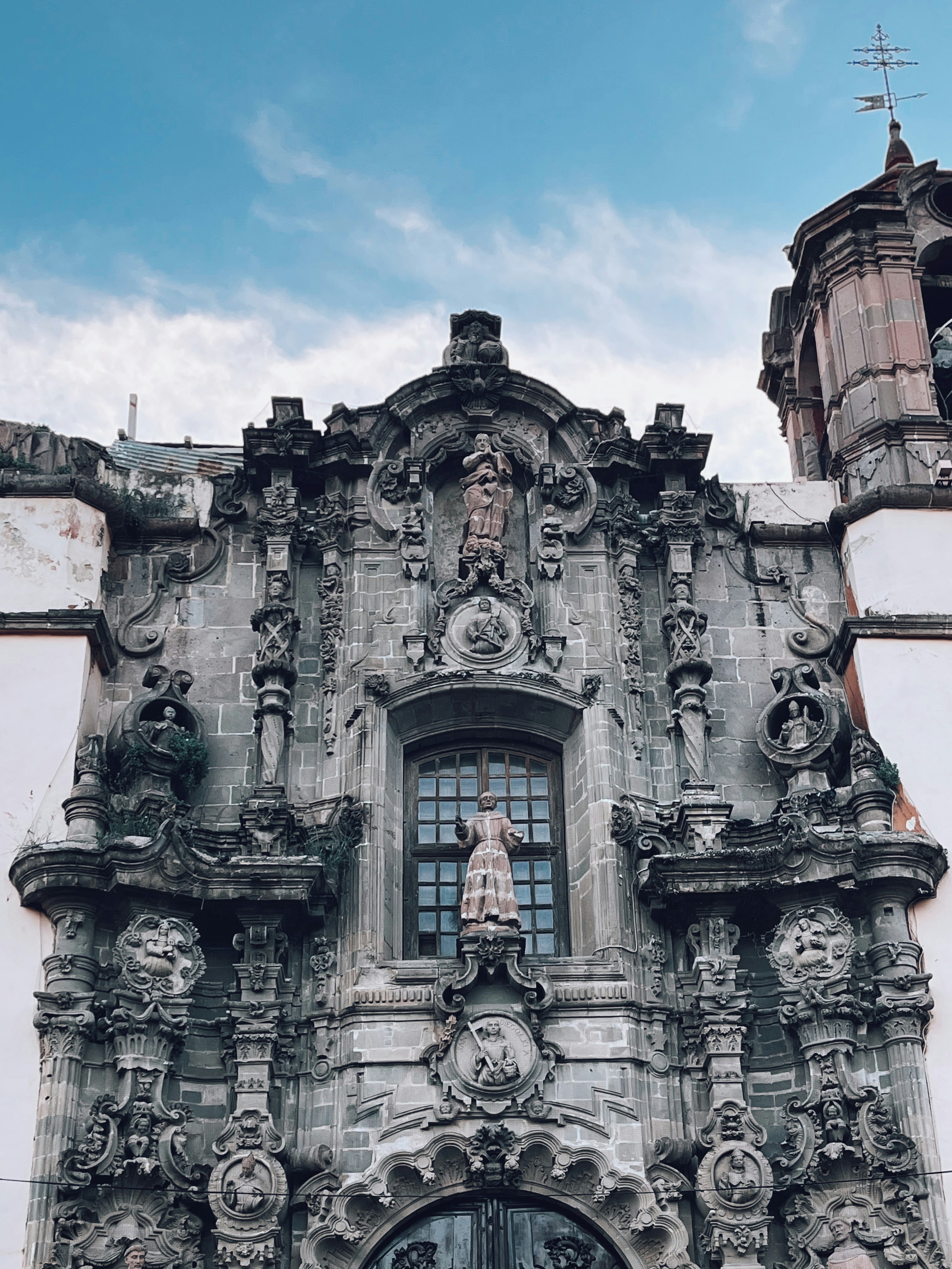 An old building with a statue on the top of it photo – Free ...