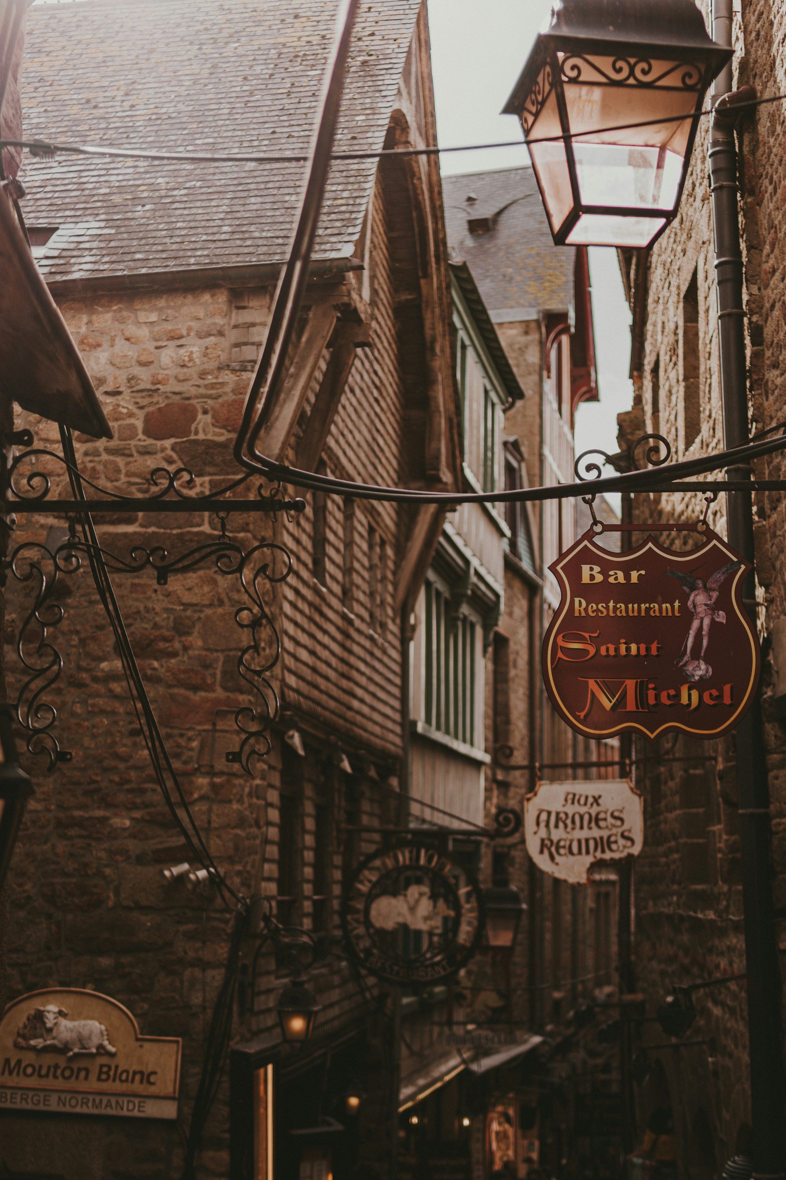 Charming alleyway adorned with vintage signs and warm lanterns, capturing the essence of a quaint French village.