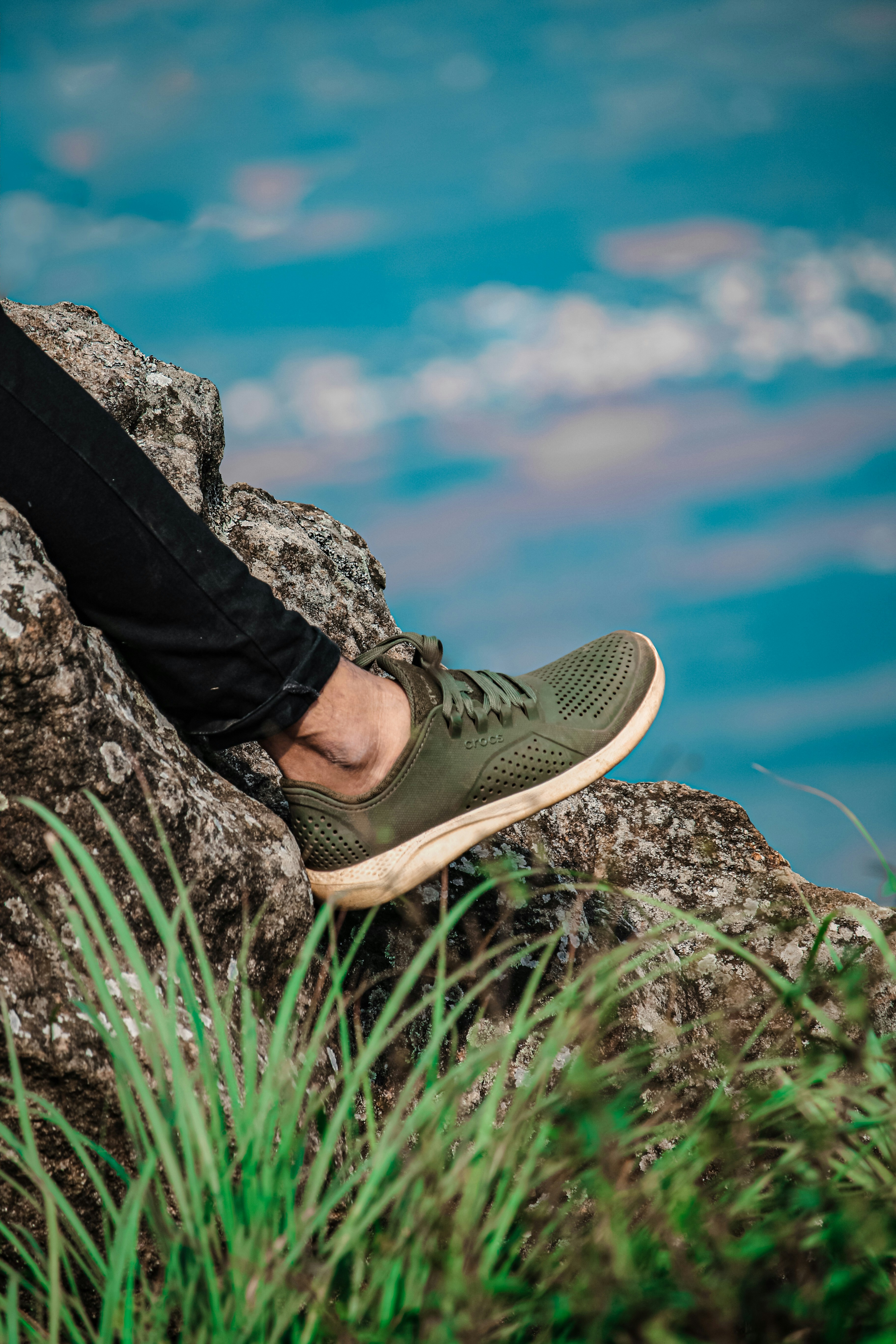 Cliffside Stance: A Green Sneaker Anchored on Weathered Granite