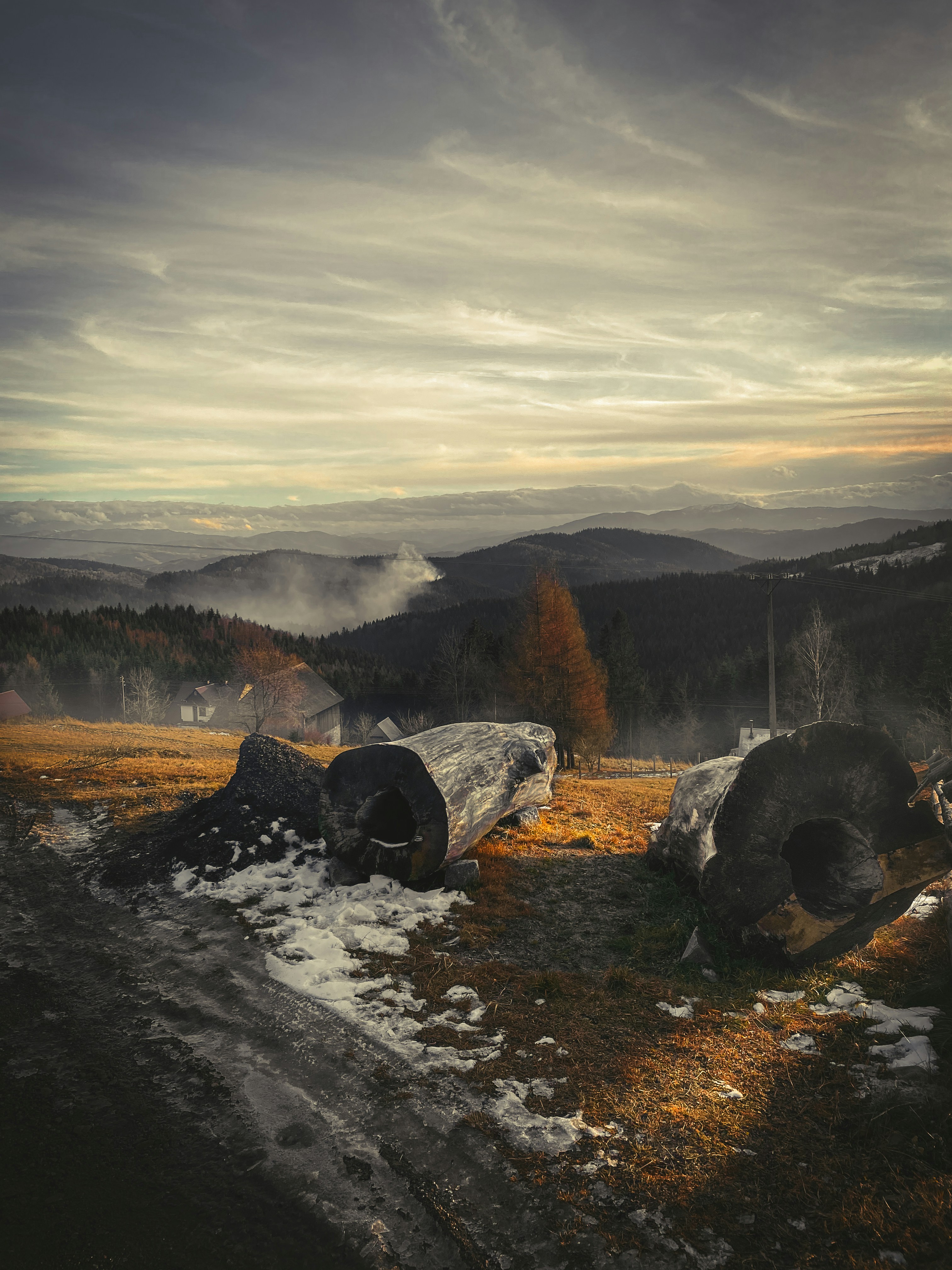 a group of logs sitting on top of a grass covered field