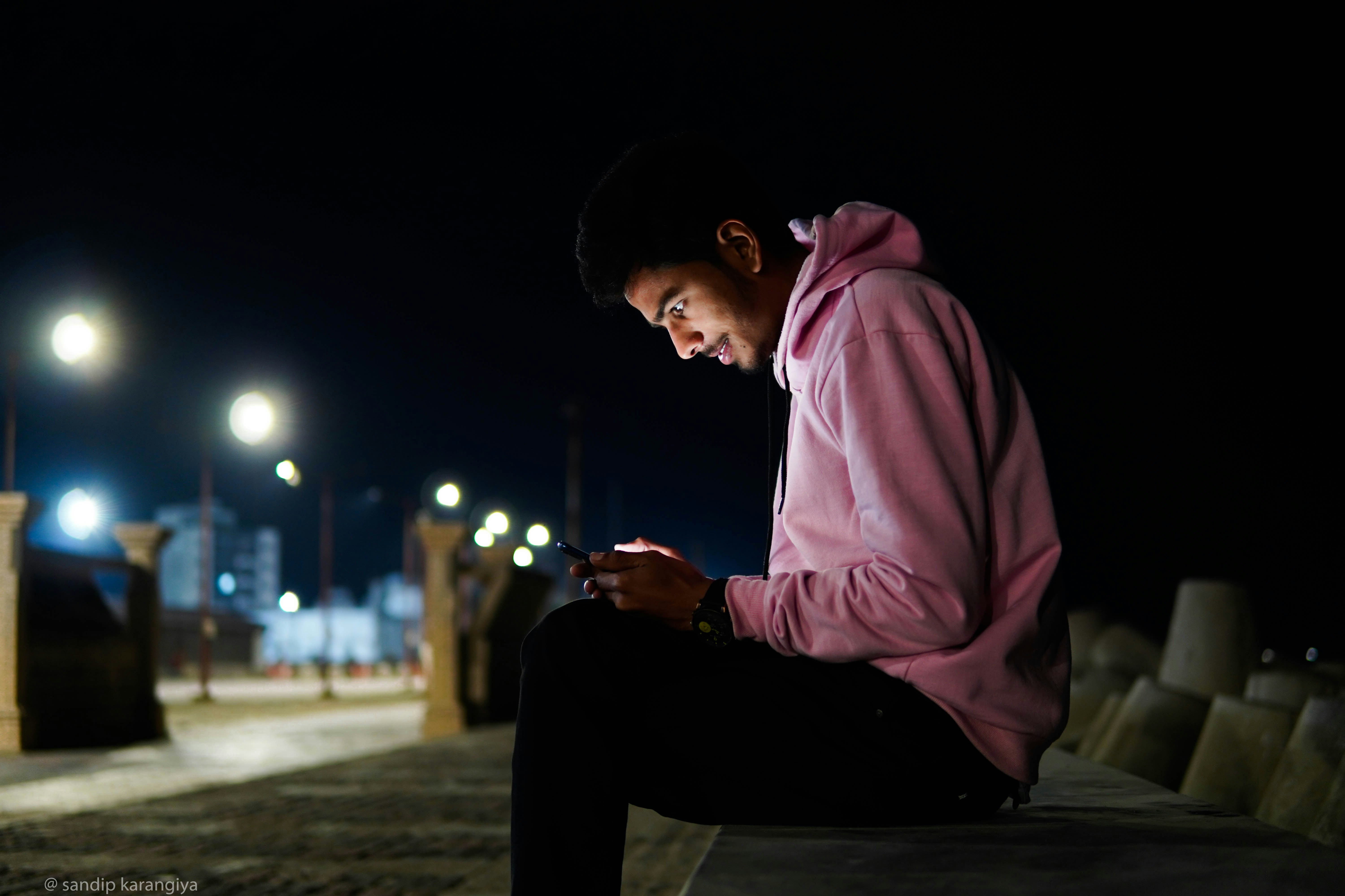 Late Night Pixel Ping: A Youth in a Pink Hoodie Under the Pier Lights