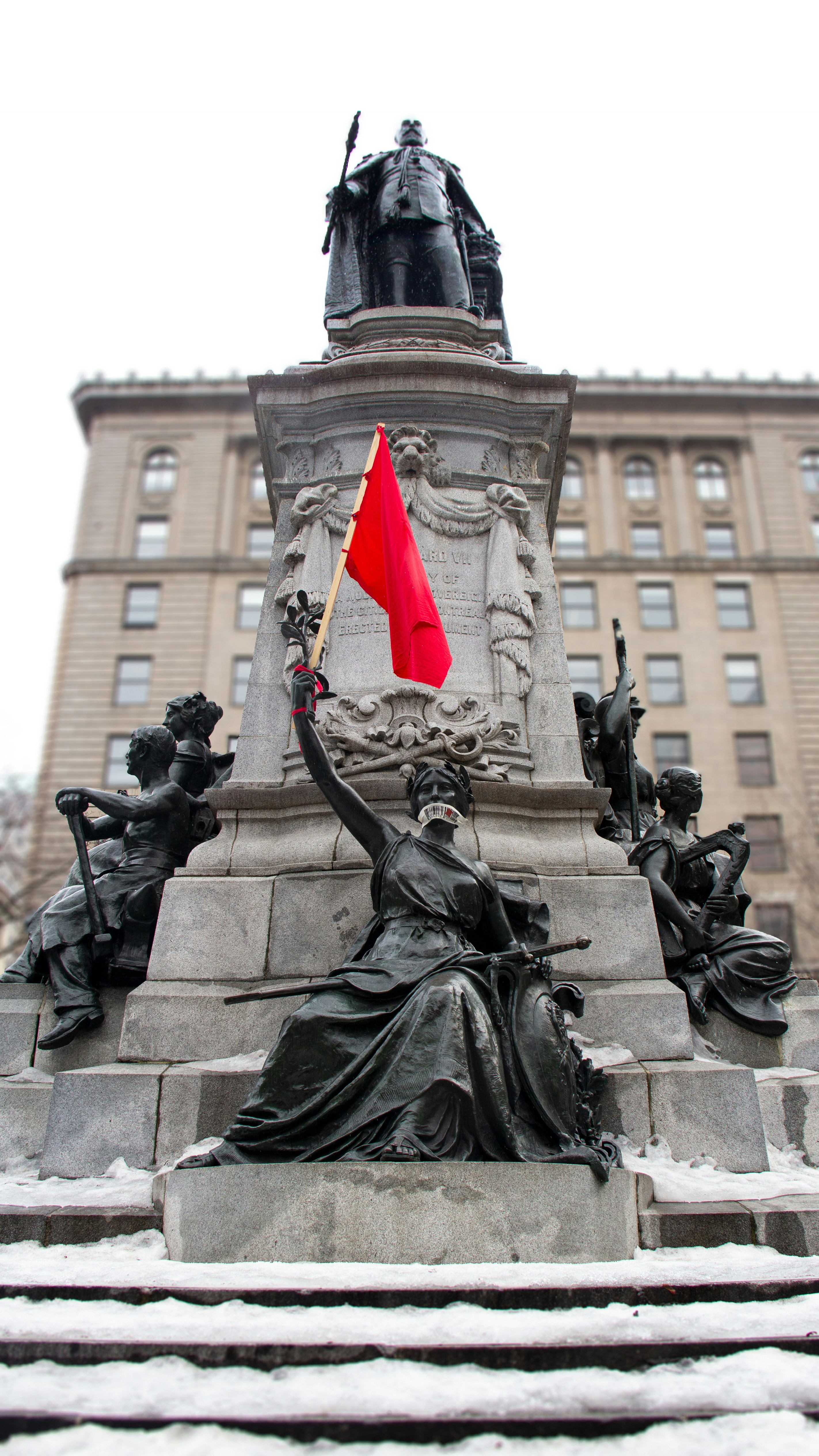 Crimson Flag on a Winter Monument: Sculpted Allegories Guard the City