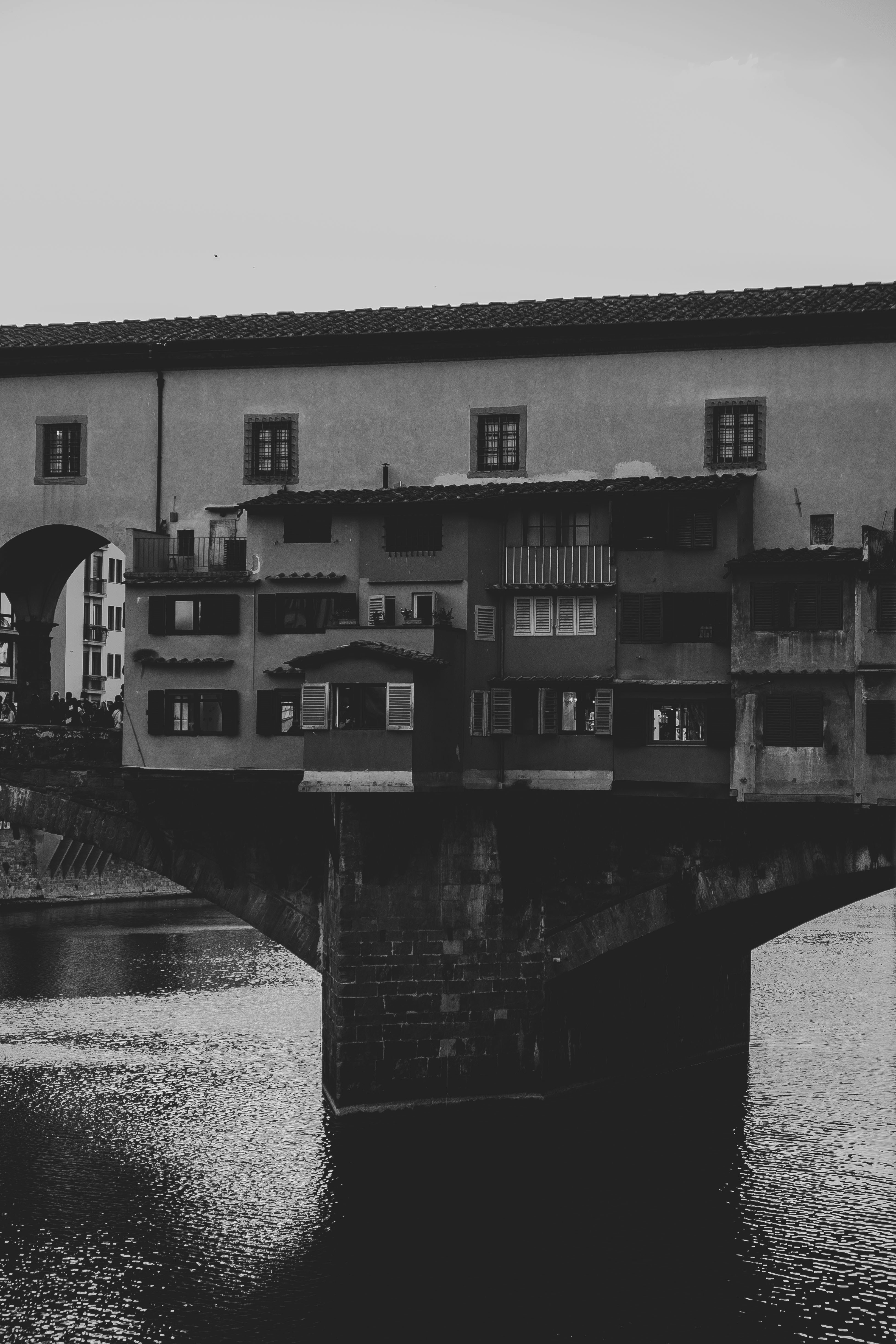 a black and white photo of a bridge over a body of water