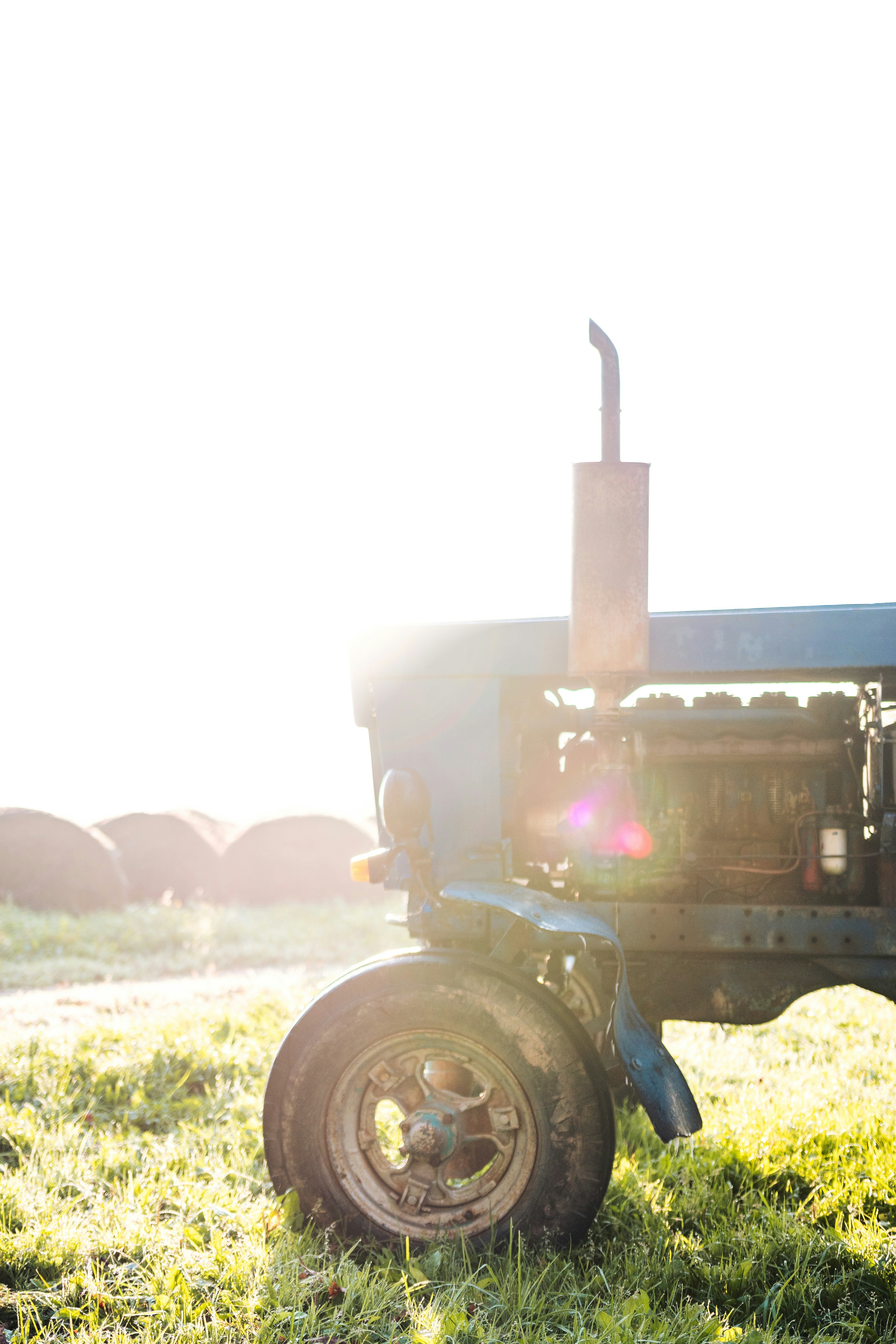 A tractor is parked in a field of grass photo – Free Veclaicene Image ...