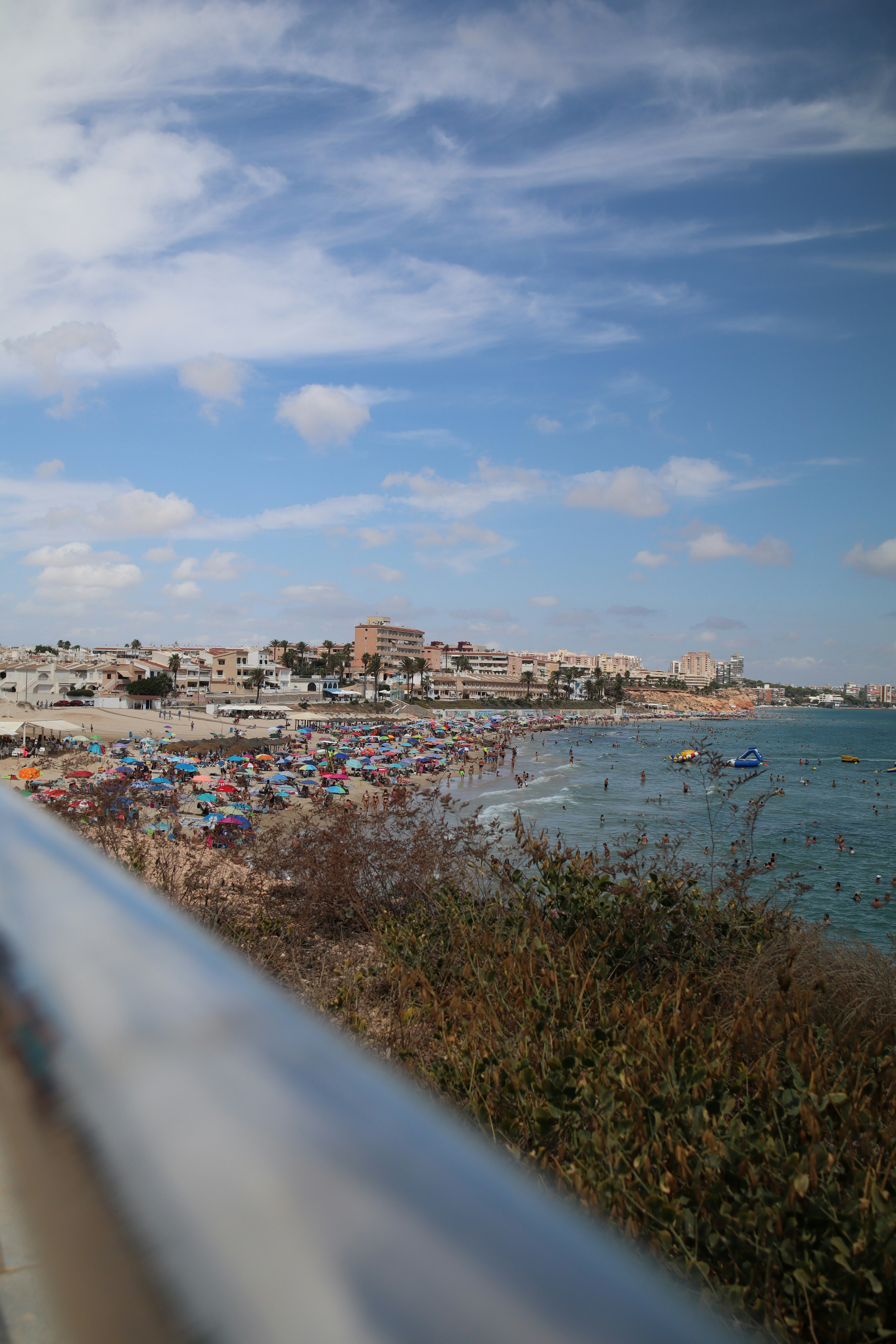 Colorful Umbrella Coast: A Busy Beach Framed by Coastal Buildings