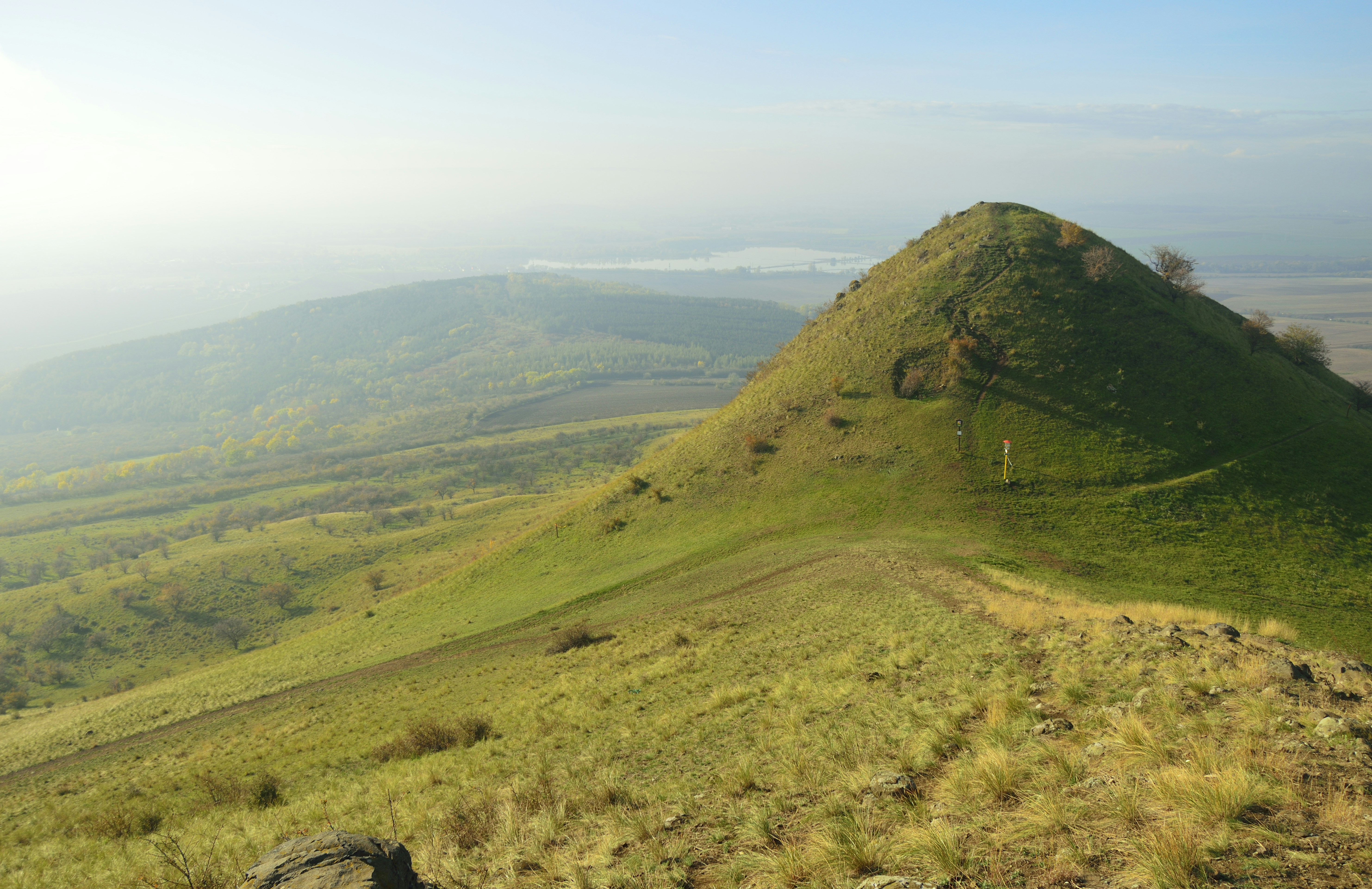 A grassy hill with a large rock in the foreground photo – Free Oblík ...