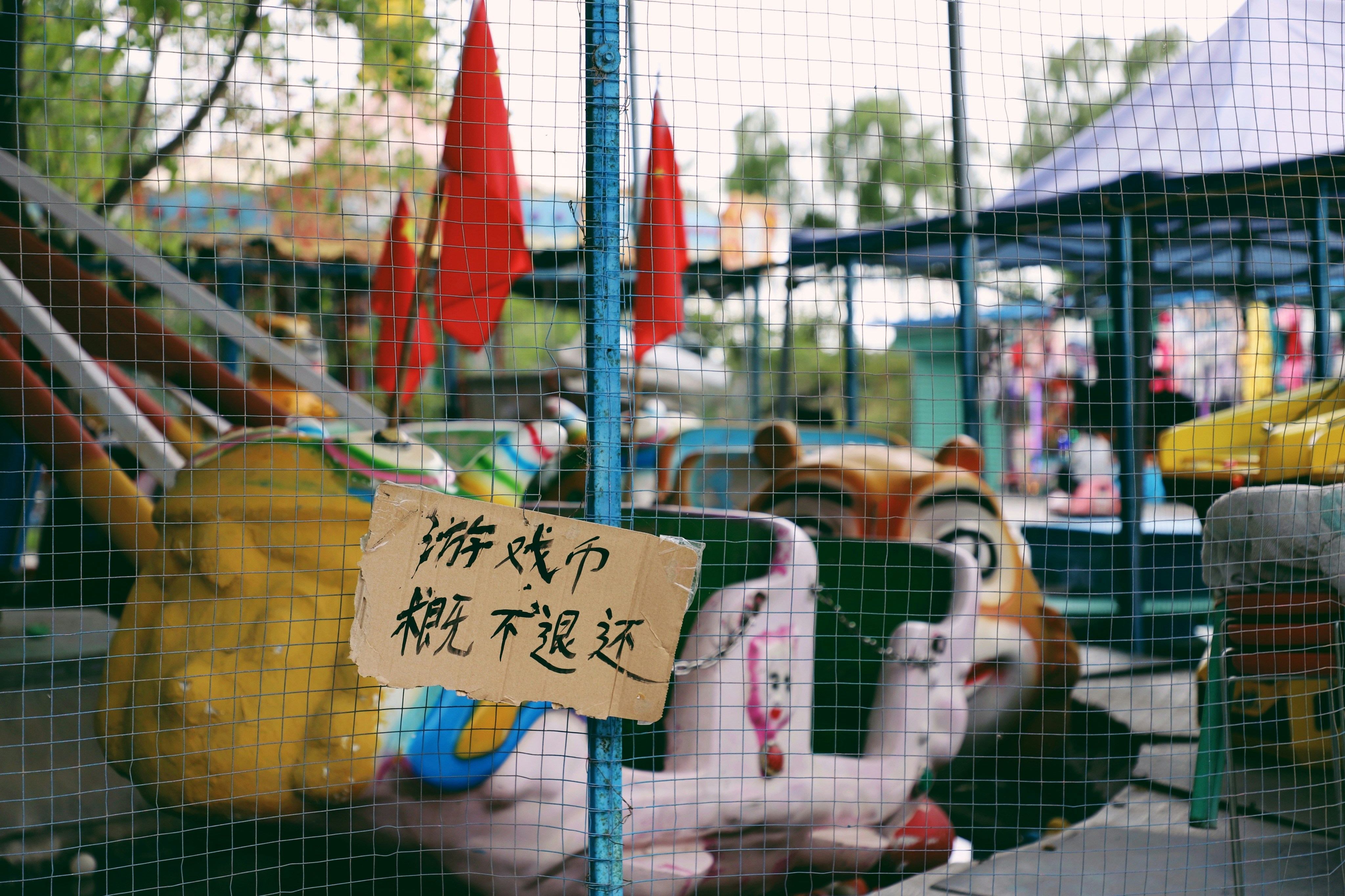 a sign that is on a fence in front of a carnival