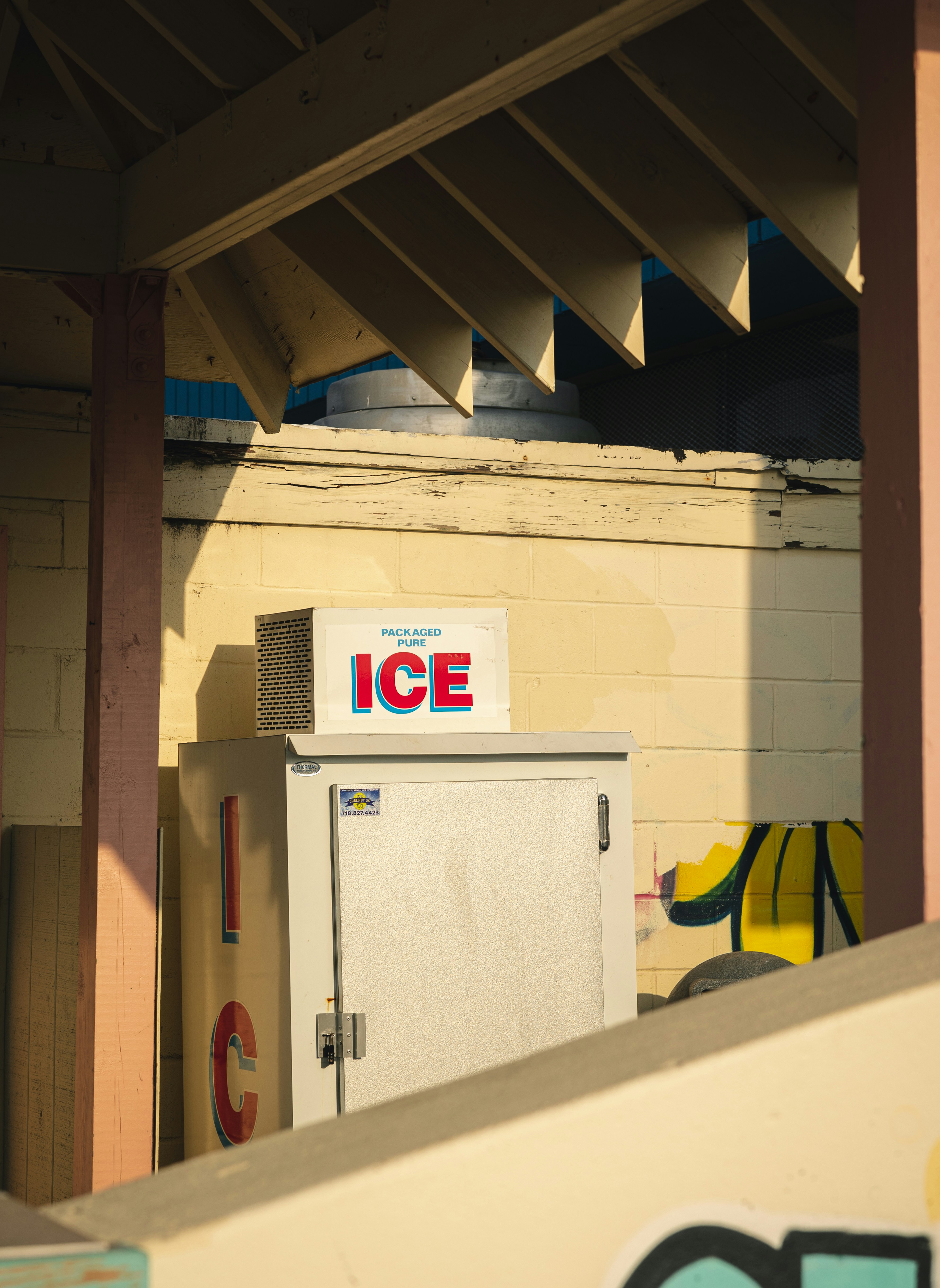 A white ice box sitting next to a building photo – Free Appliance Image ...