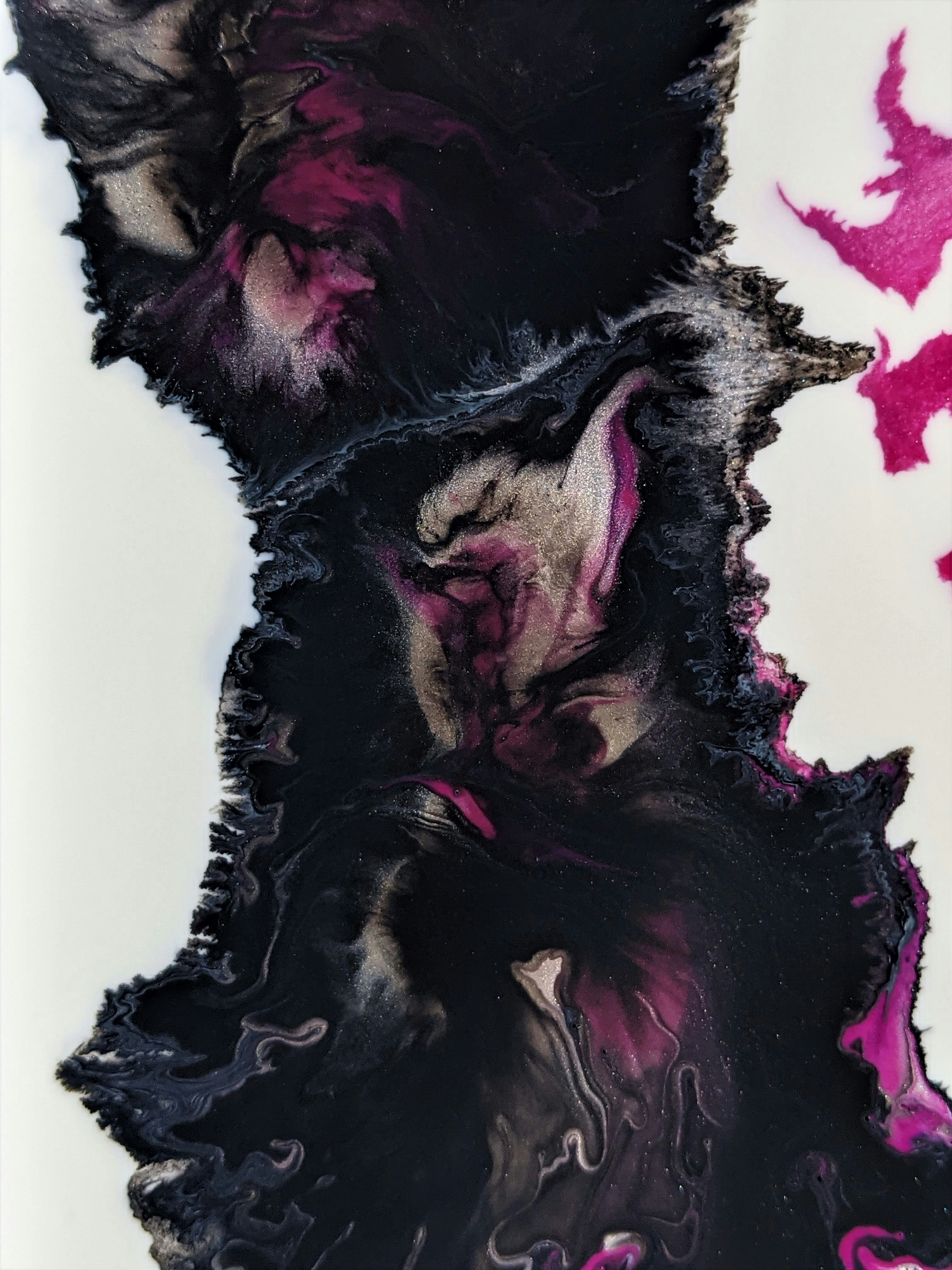 Abstract artwork featuring swirling patterns of black and vibrant pink against a white background. The fluidity of the colors creates a sense of movement.