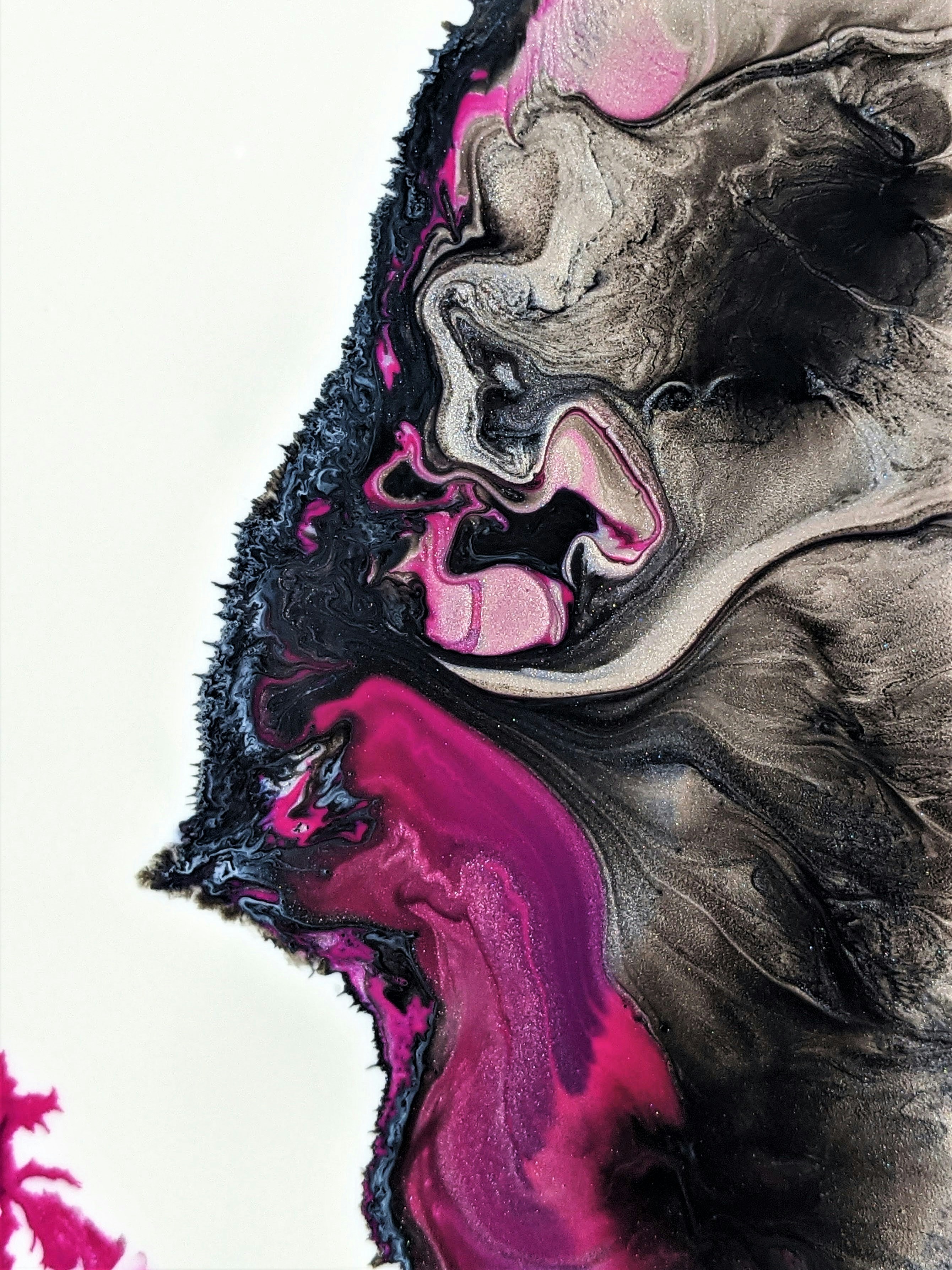 An abstract fluid art piece showcasing swirling patterns of pink, black, and gray against a white background. The intricate designs evoke a sense of movement and emotion.