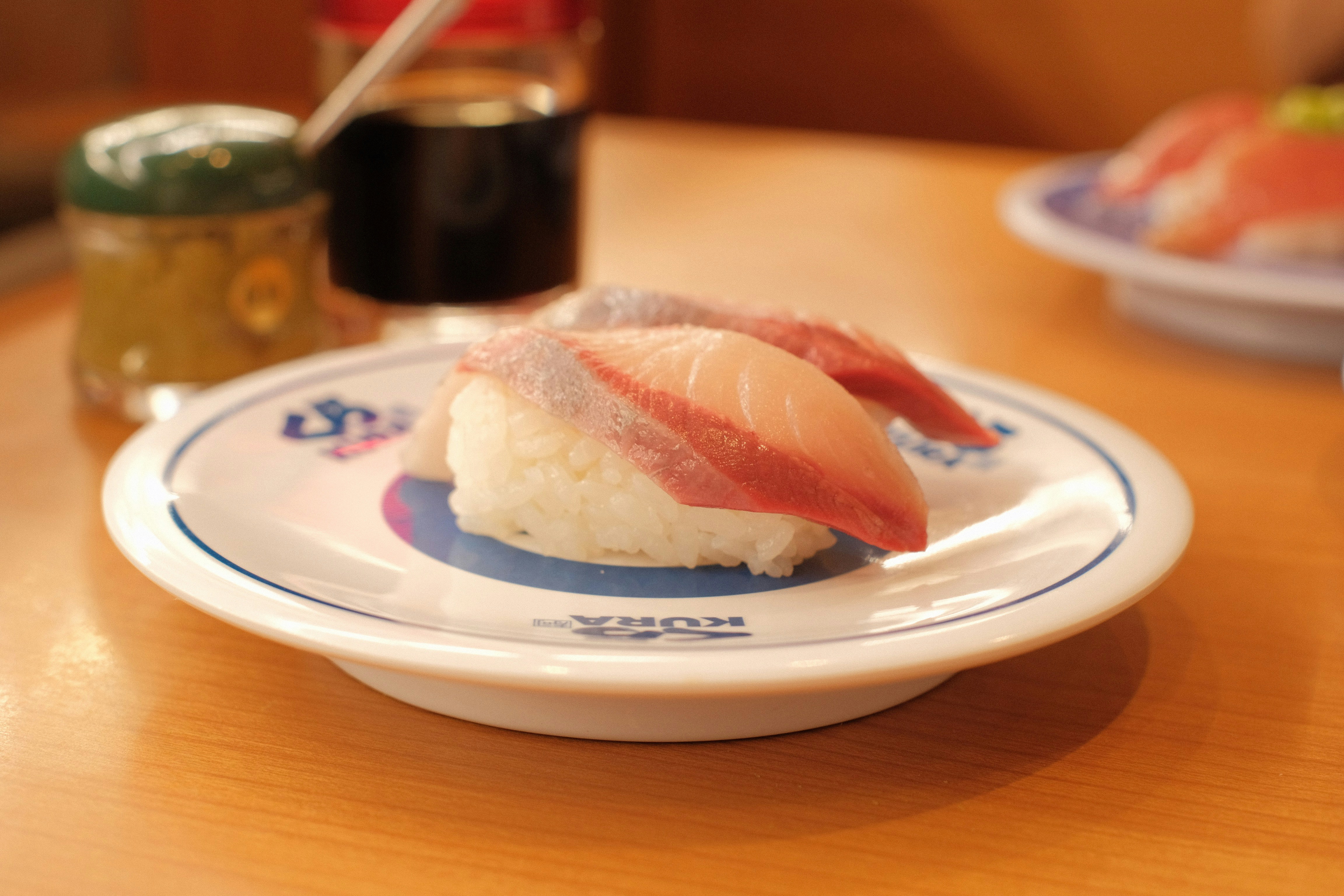 Sunlit Nigiri on a Sushi Plate at a Quiet Counter