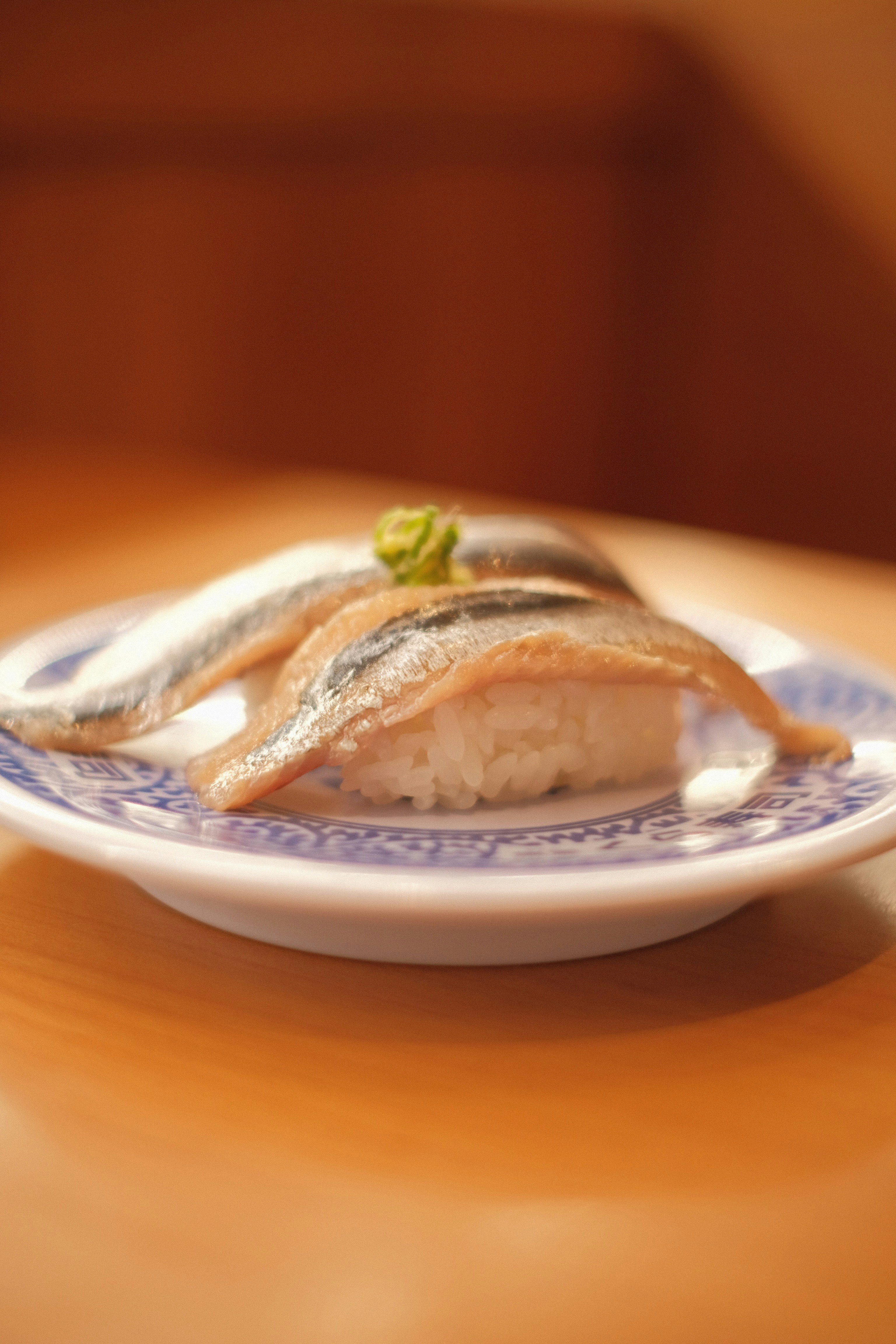 a piece of sushi sitting on top of a blue and white plate