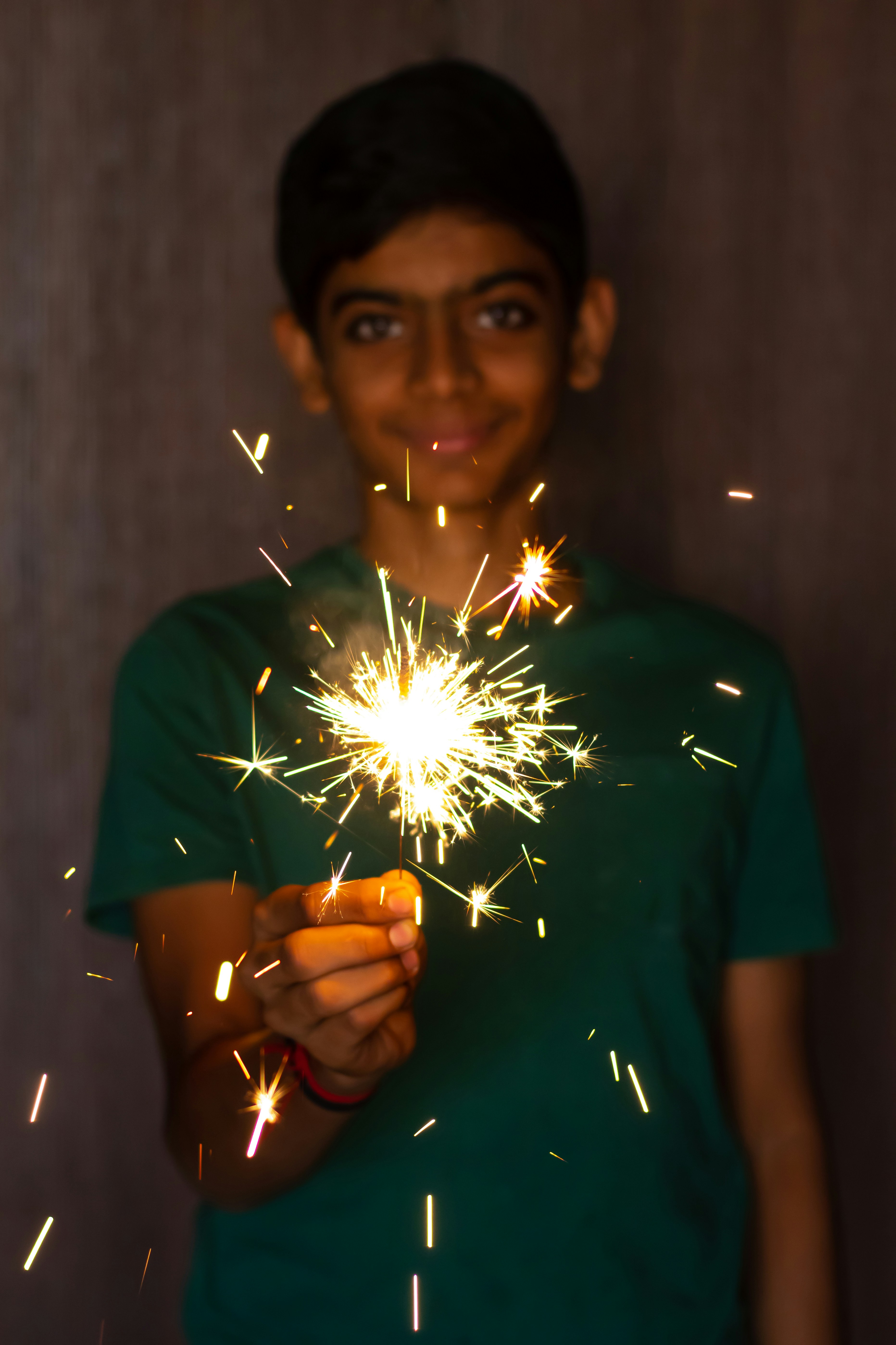 A young boy holding a sparkler in his hands photo – Free Surat Image on ...