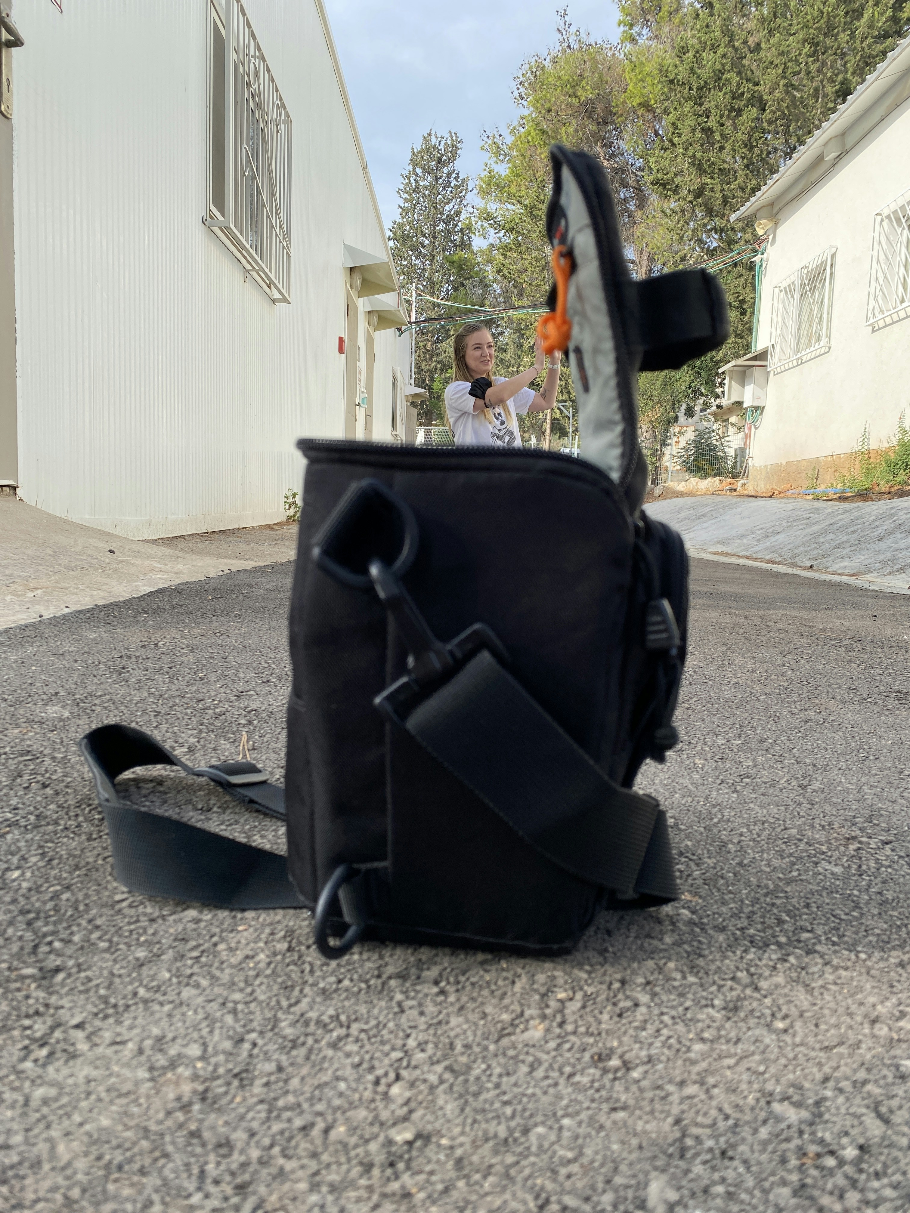 Foreground Gear, Street Scene: A Black Camera Bag Anchors a Quiet Photographic Setup