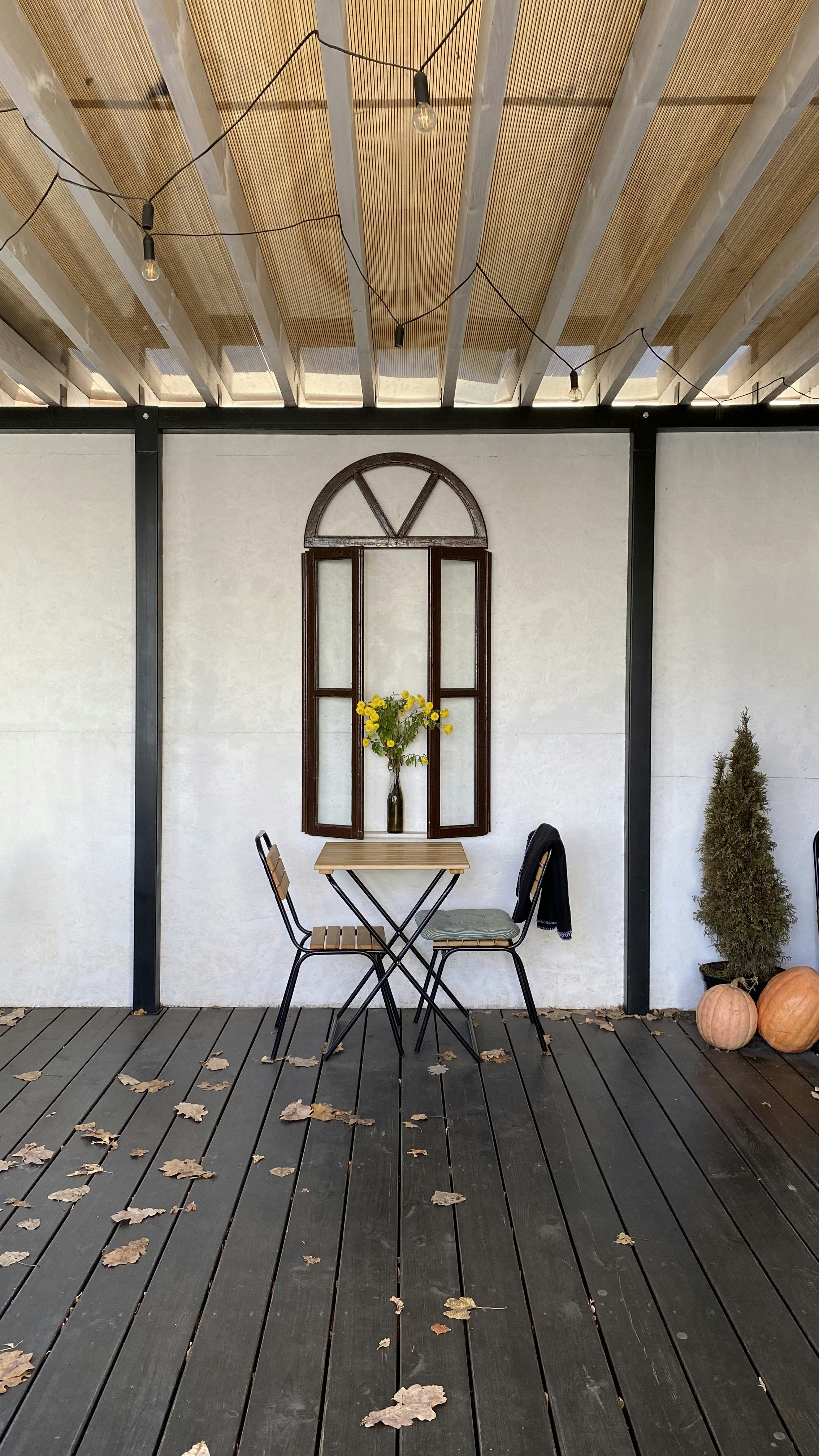 Autumn Porch Still-Life: A Vase of Yellow Blooms Framed by a Window Arch