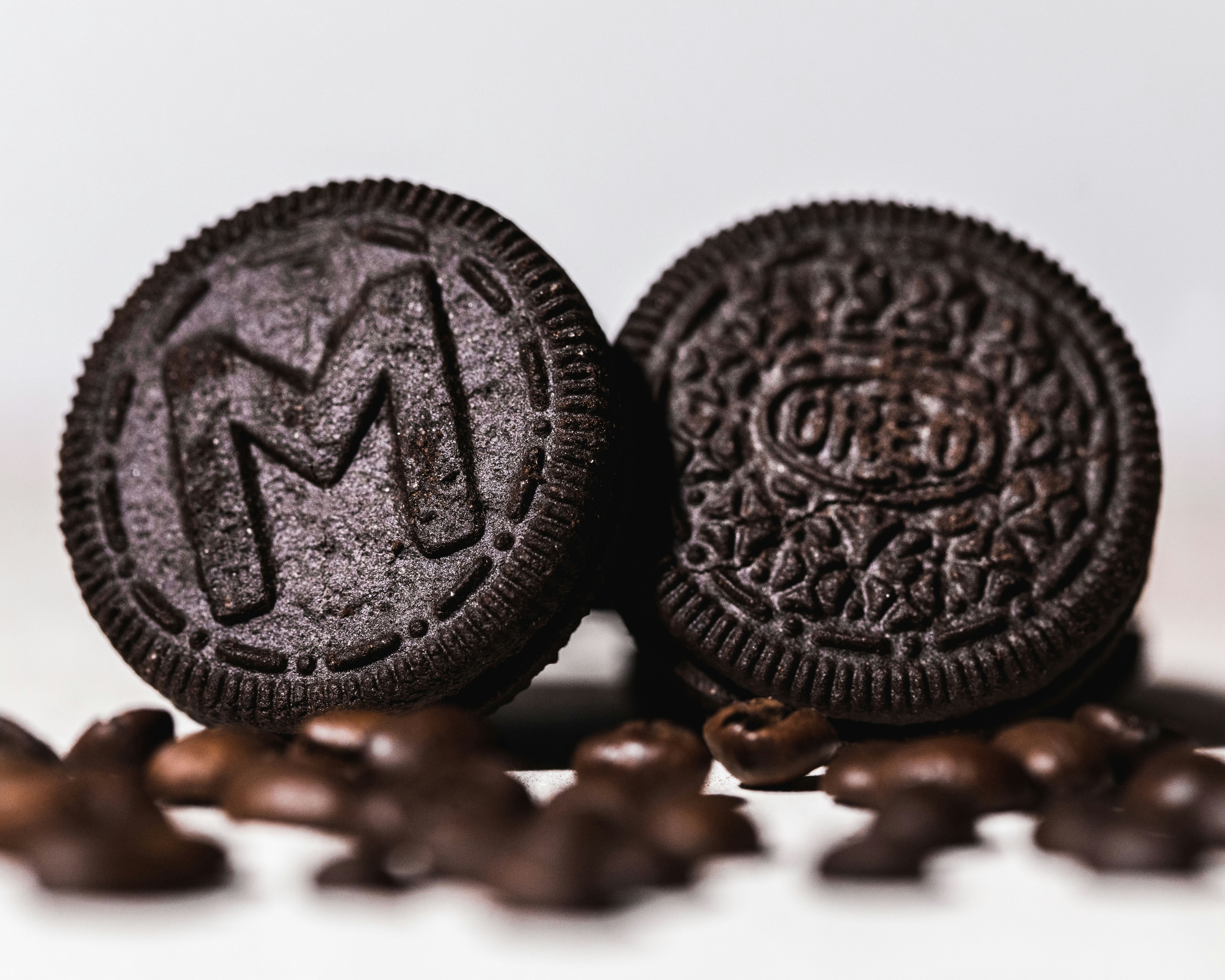 Two oreos sitting on top of a pile of coffee beans photo – Free Food ...