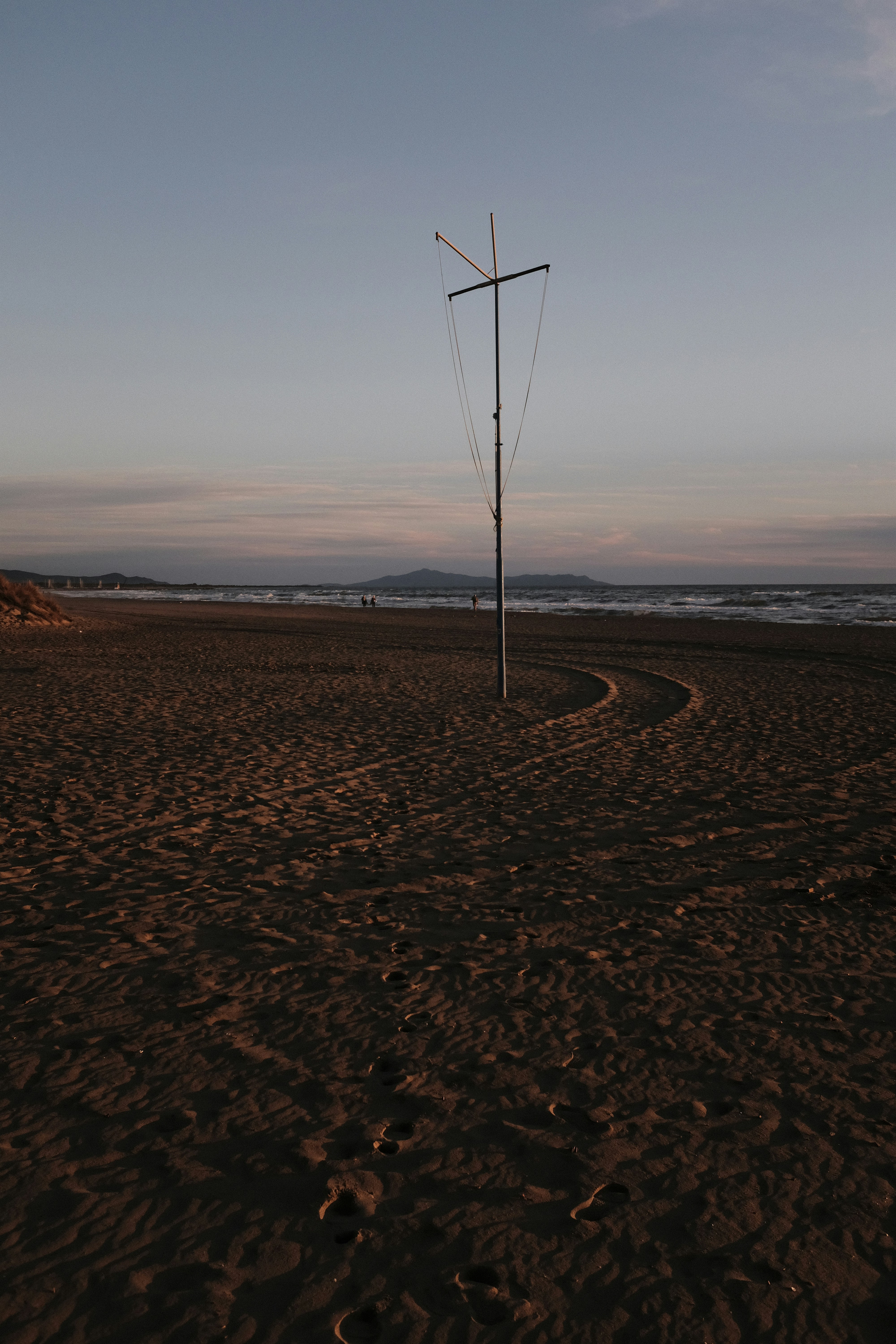 a telephone pole on a sandy beach near the ocean