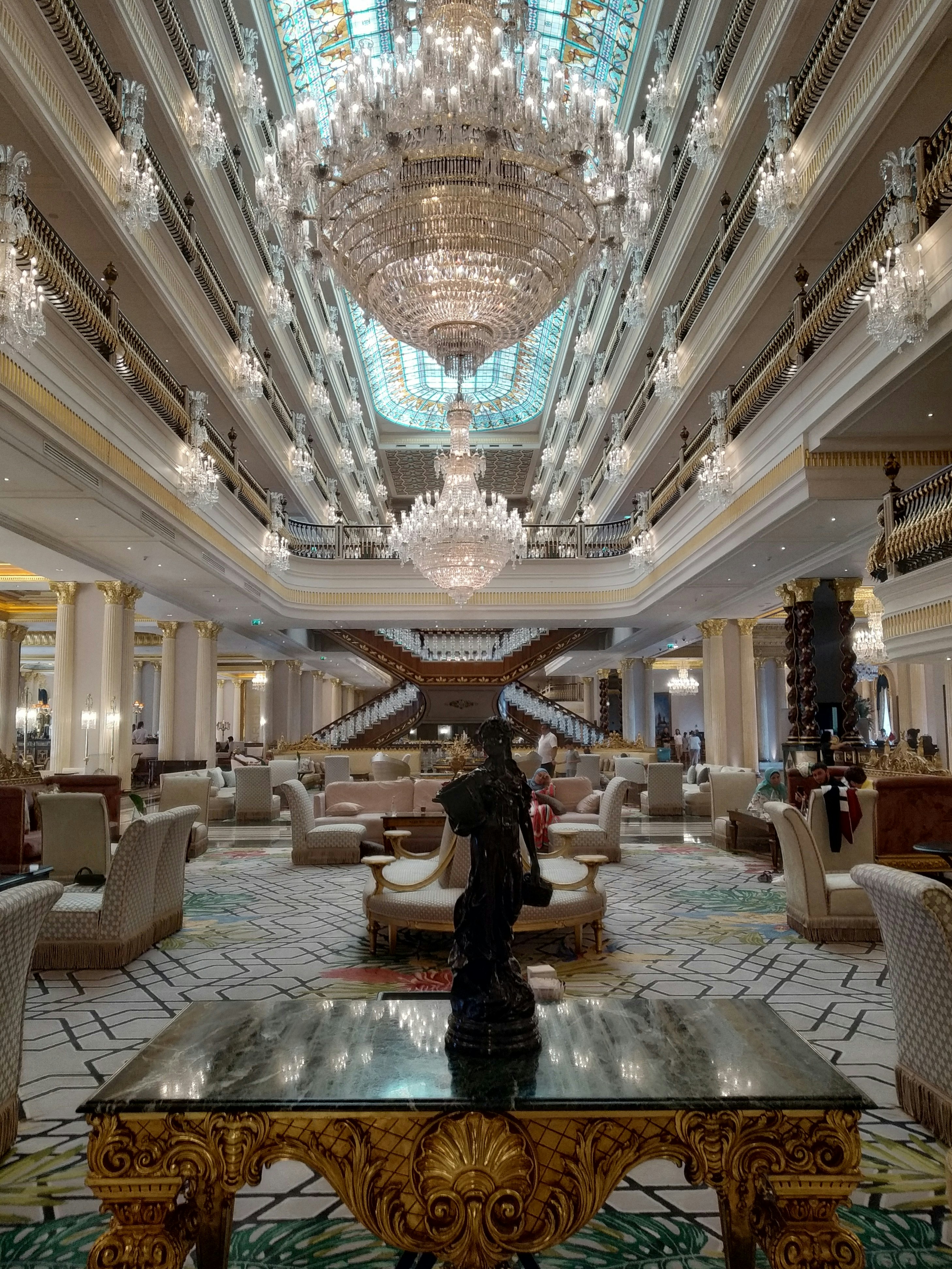 A fancy hotel lobby with chandeliers and seating photo – Free Lobby ...