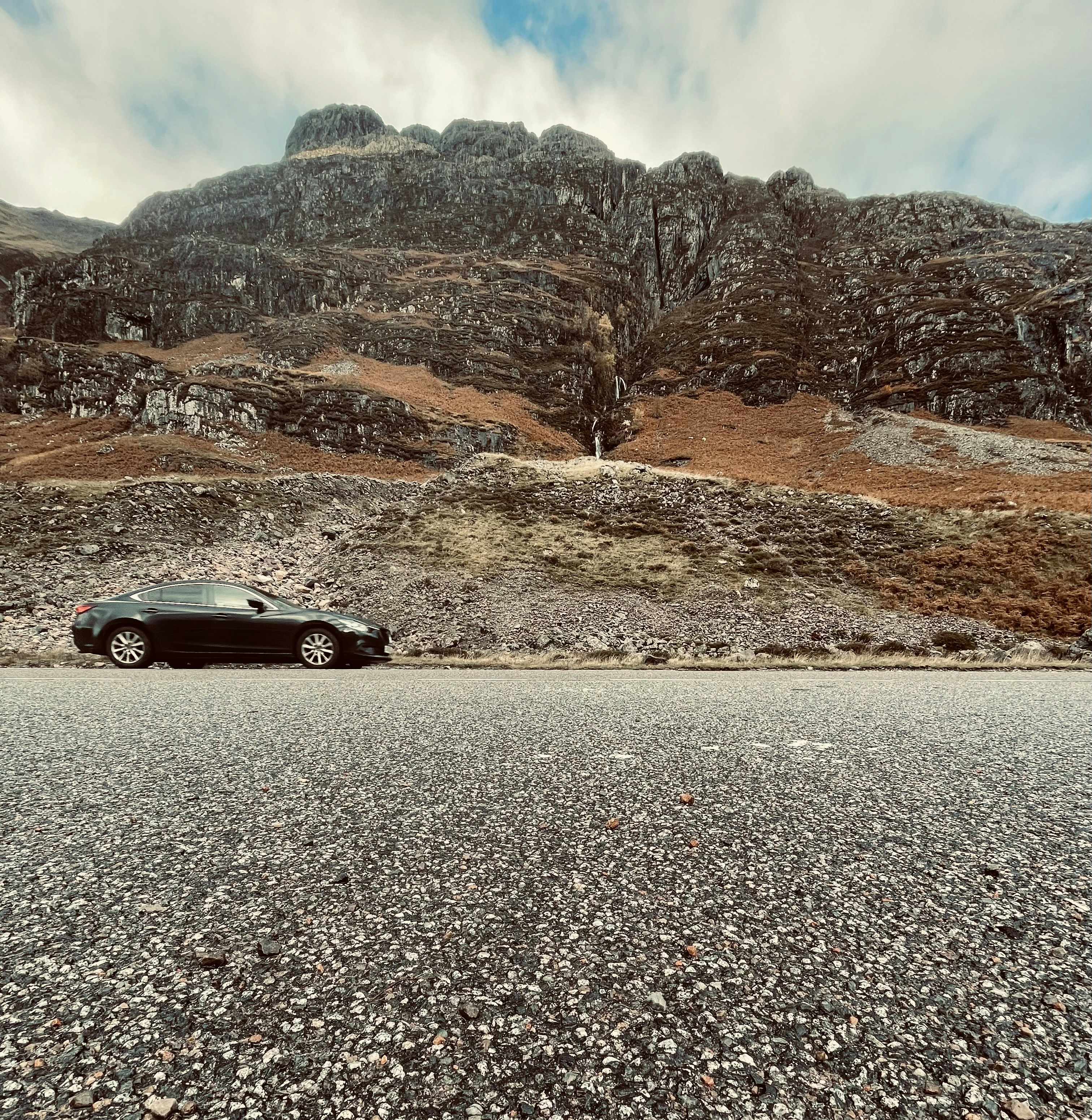 a black car parked on the side of a road